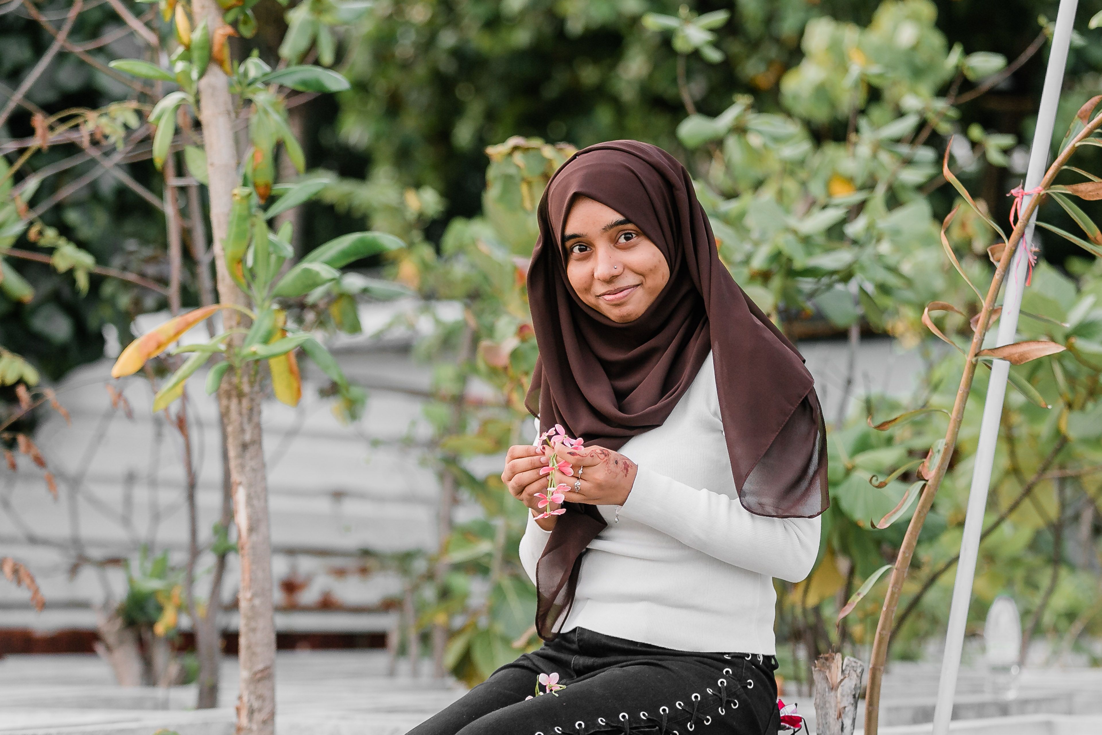 Positive Muslim woman standing in lush park · Free Stock Photo