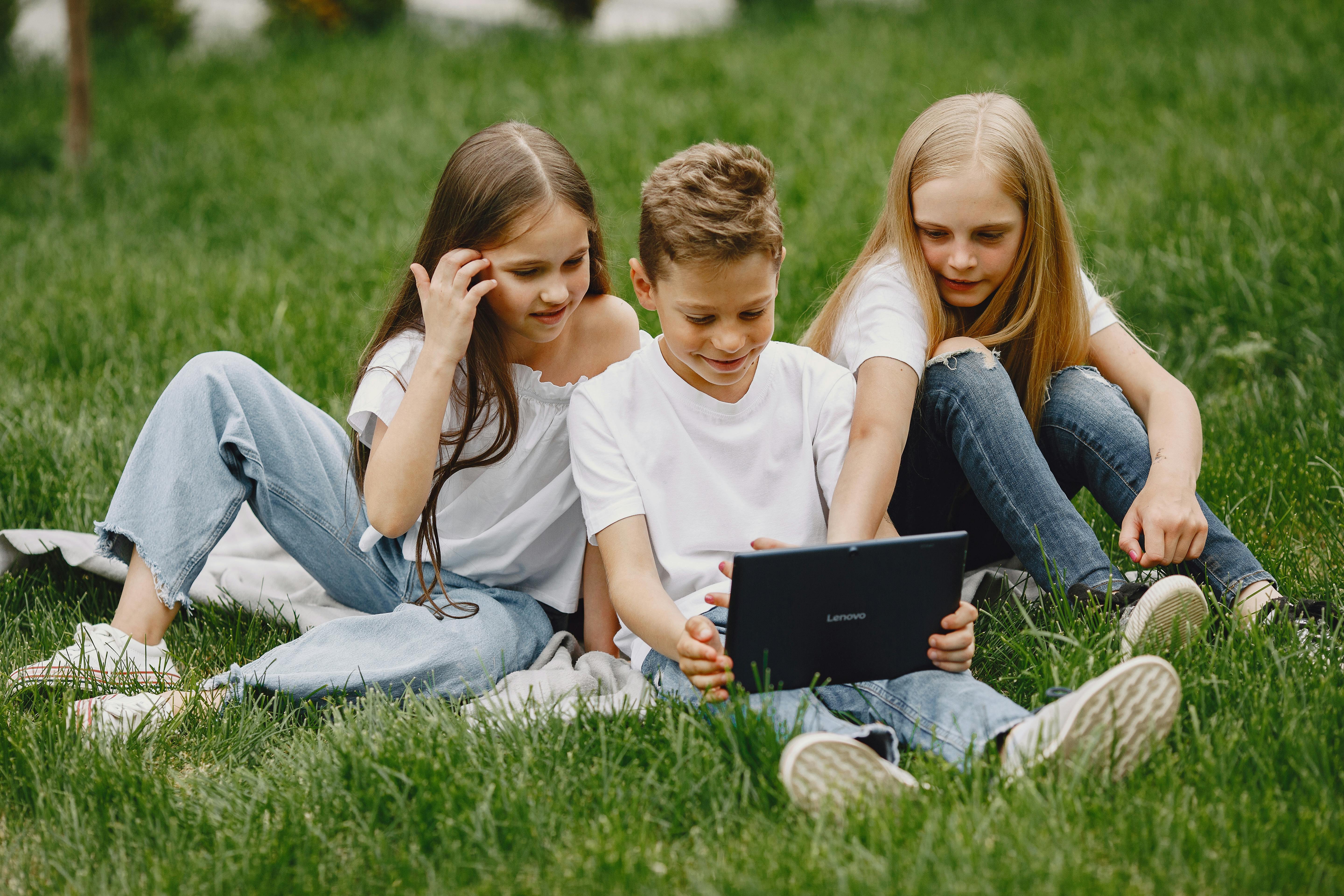 Kids Sitting on the Ground with a Tablet · Free Stock Photo