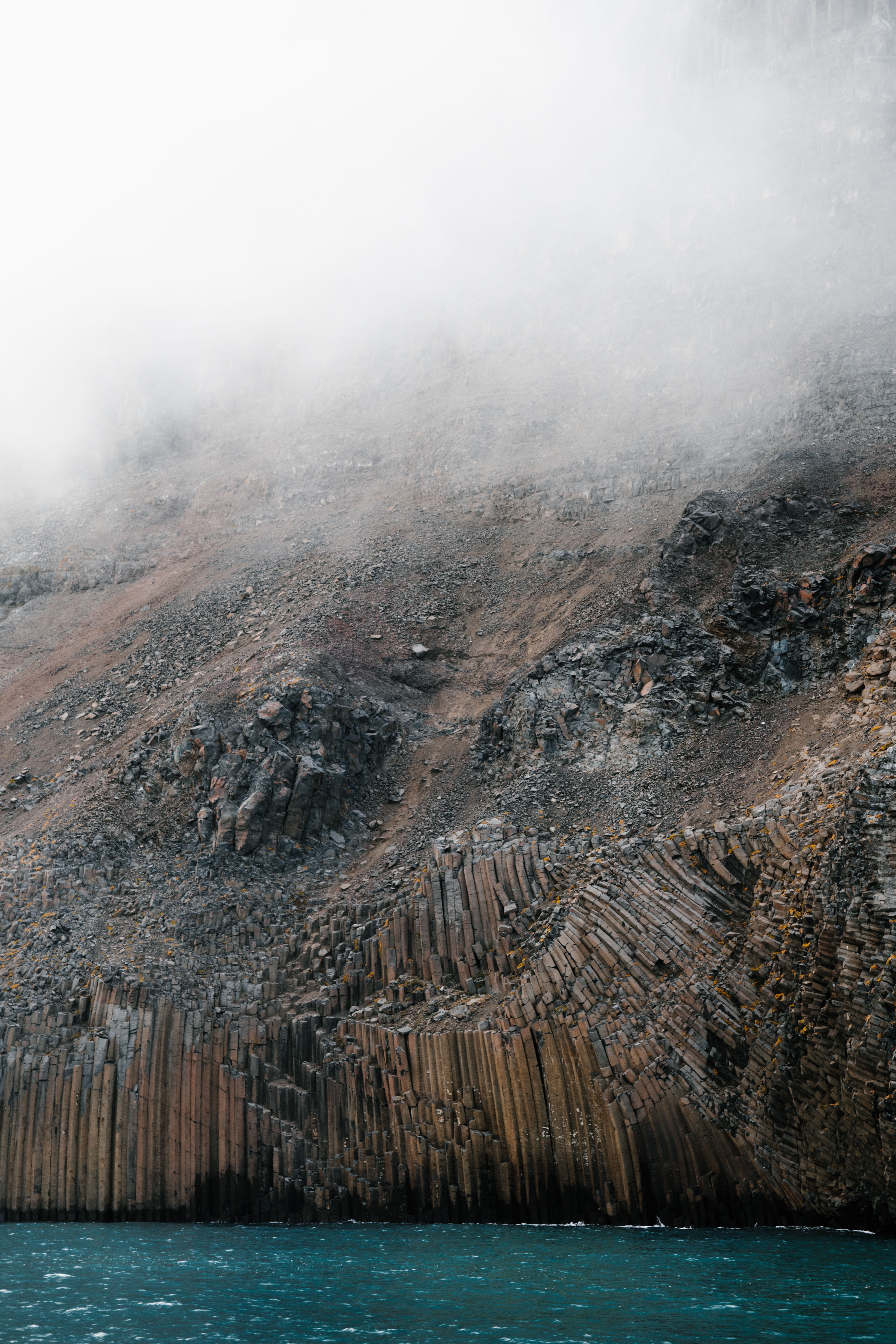 Cliff on a Seashore Covered With Fog · Free Stock Photo