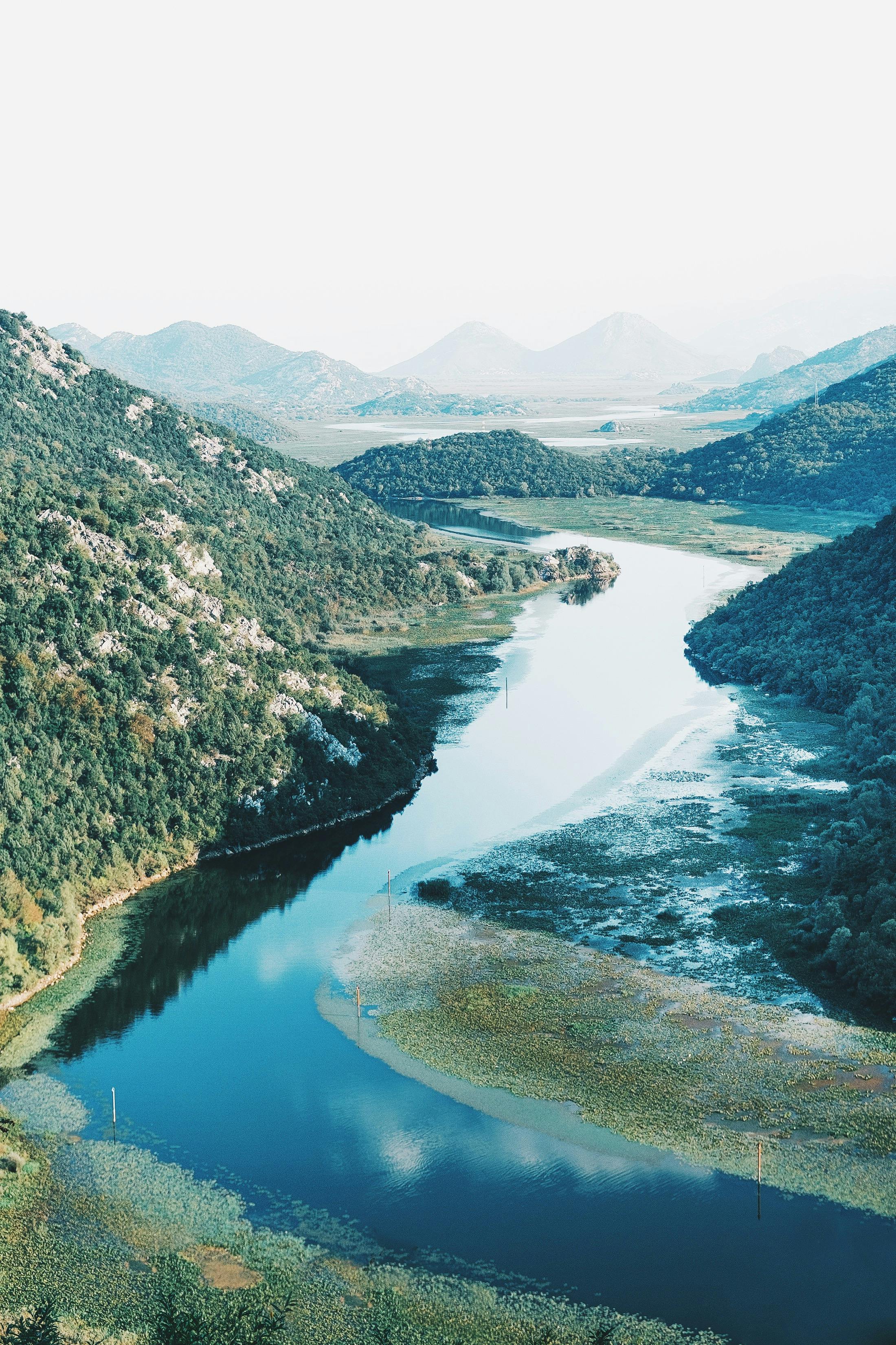 Calm narrow river in mountainous terrain · Free Stock Photo