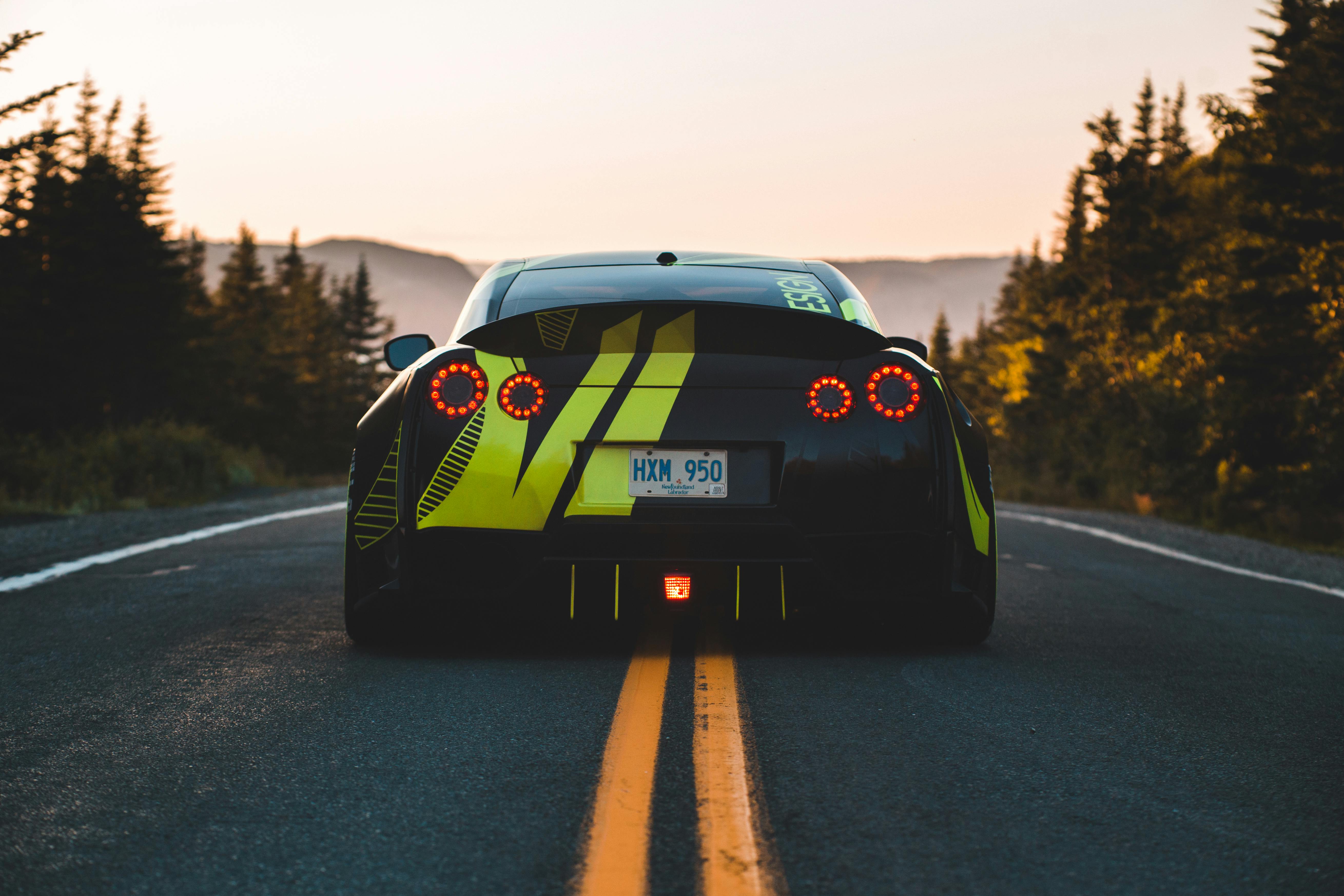 Modern sport car driving on road near forest · Free Stock Photo