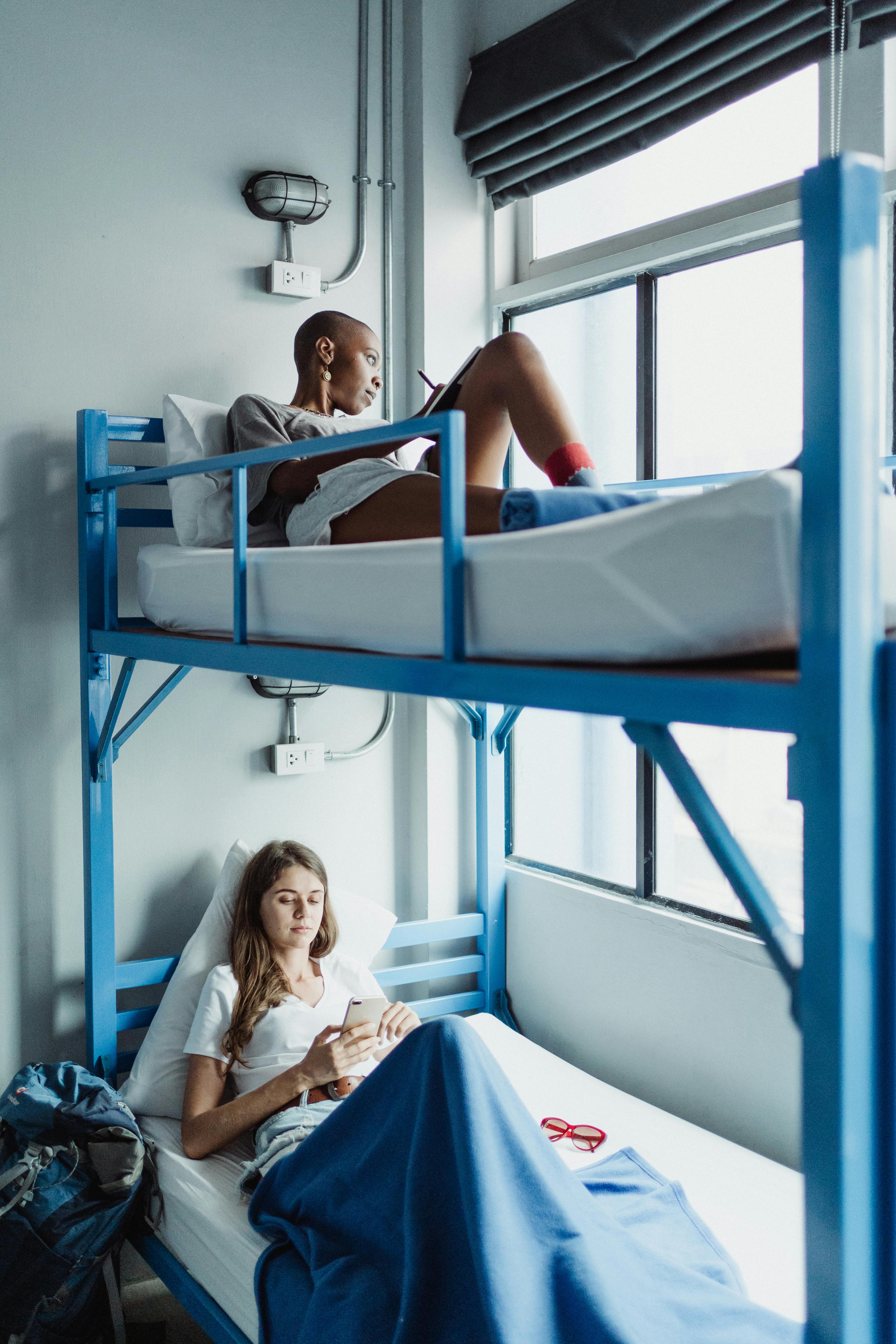 Two Women Lying on Blue Bunk Bed · Free Stock Photo