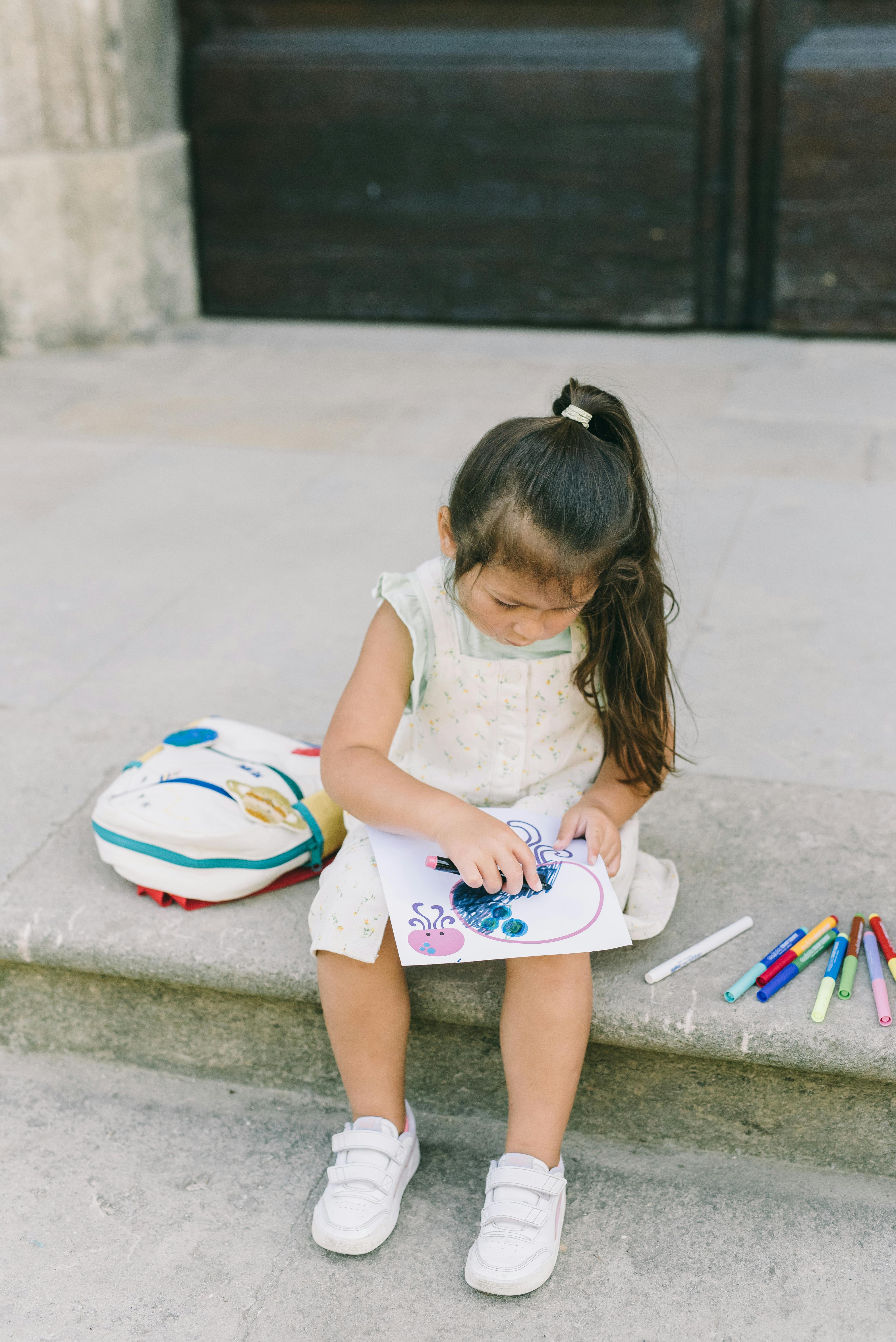 Photograph of a Girl Coloring on a Piece of Paper · Free Stock Photo