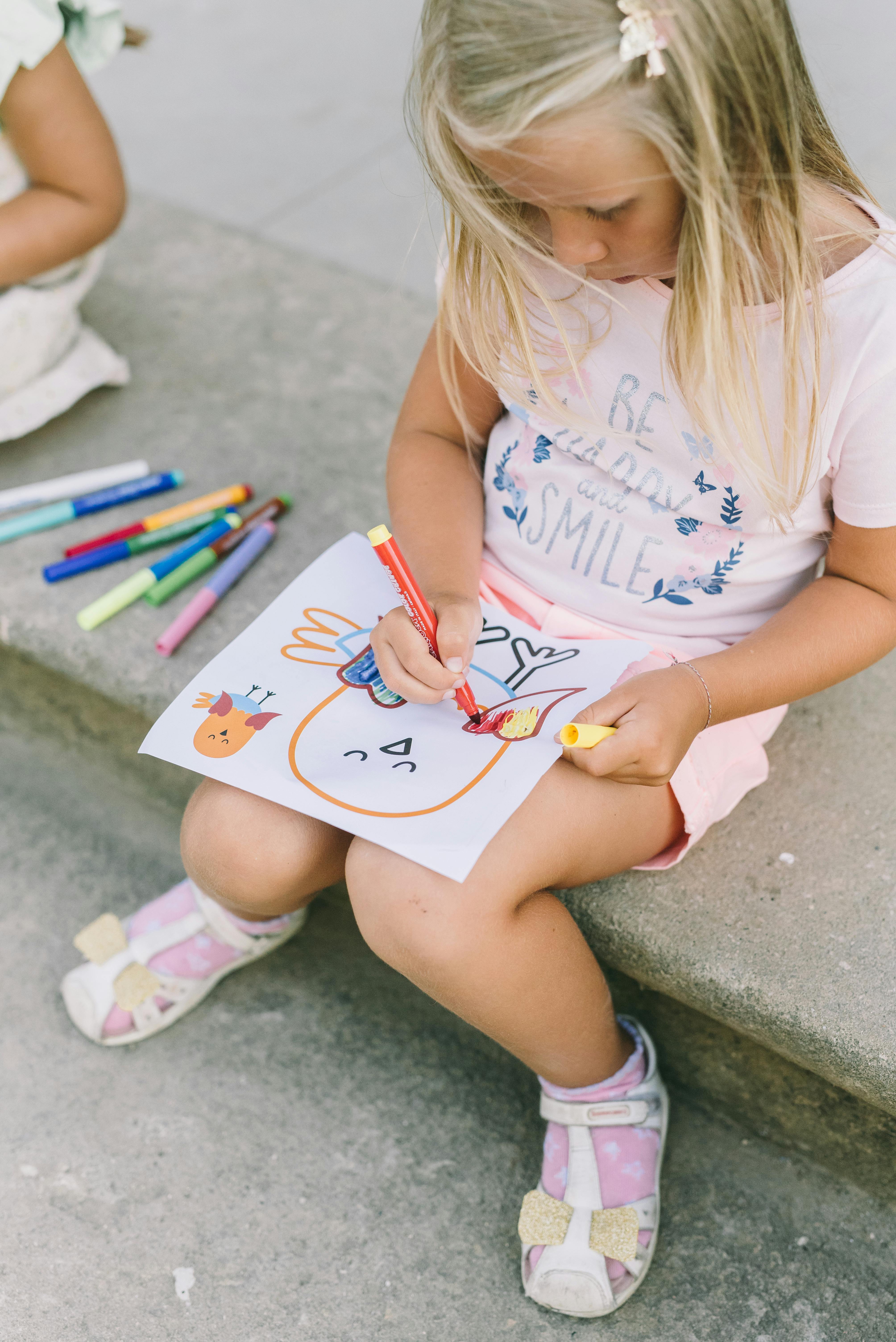 A Girl Coloring on a Paper · Free Stock Photo