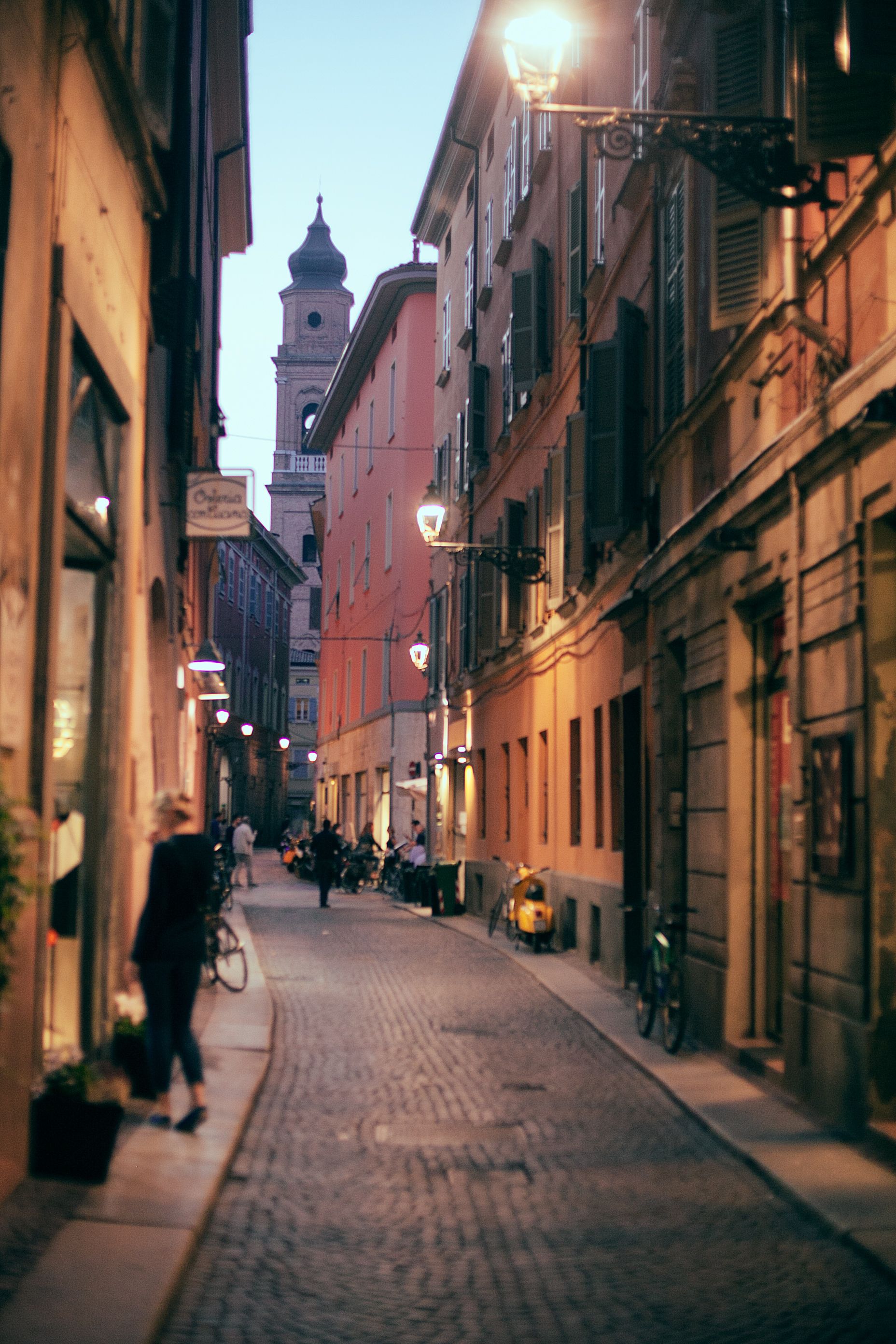 Narrow pedestrian street between old residential buildings at twilight ...