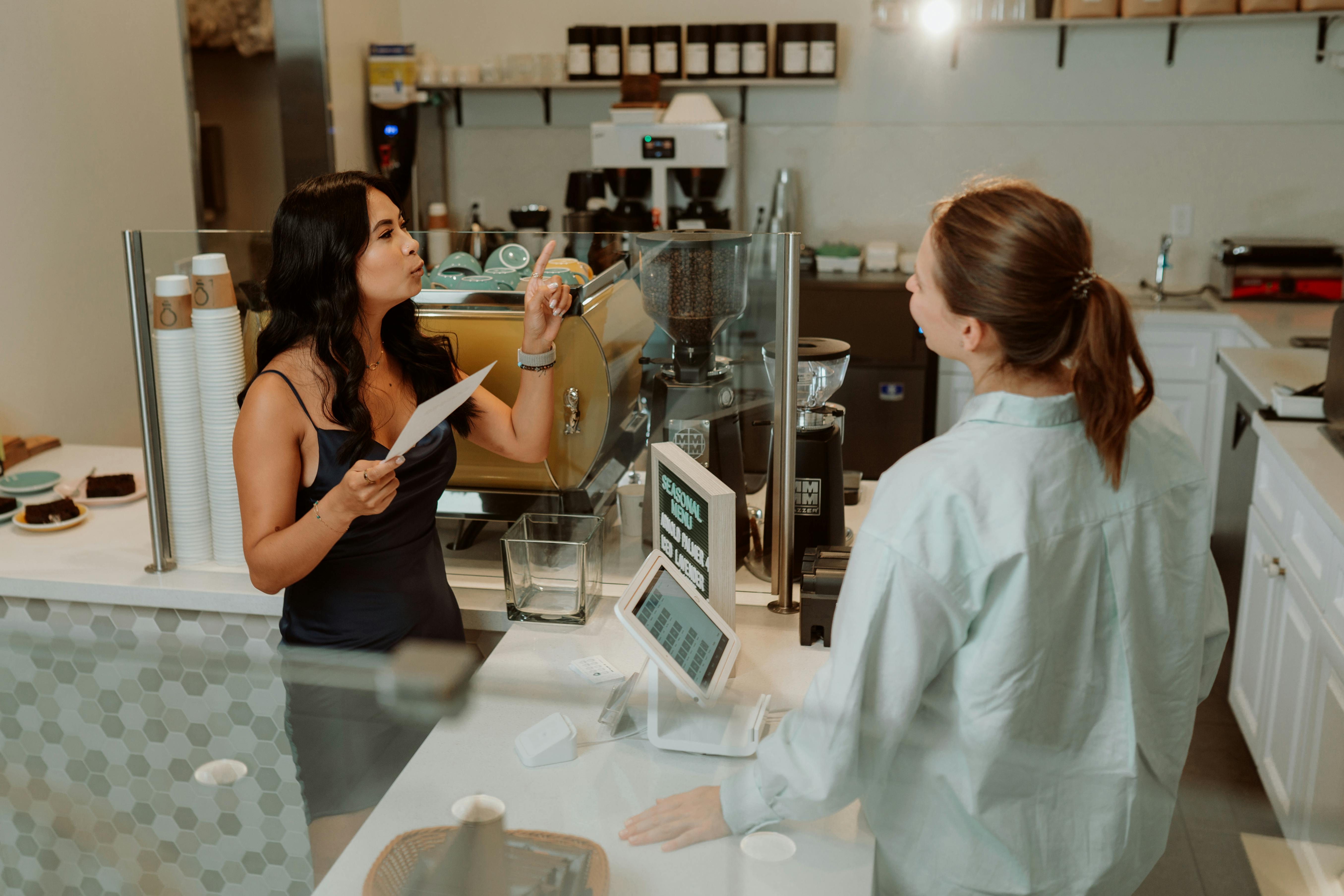 Cheerful black waitress standing at counter · Free Stock Photo