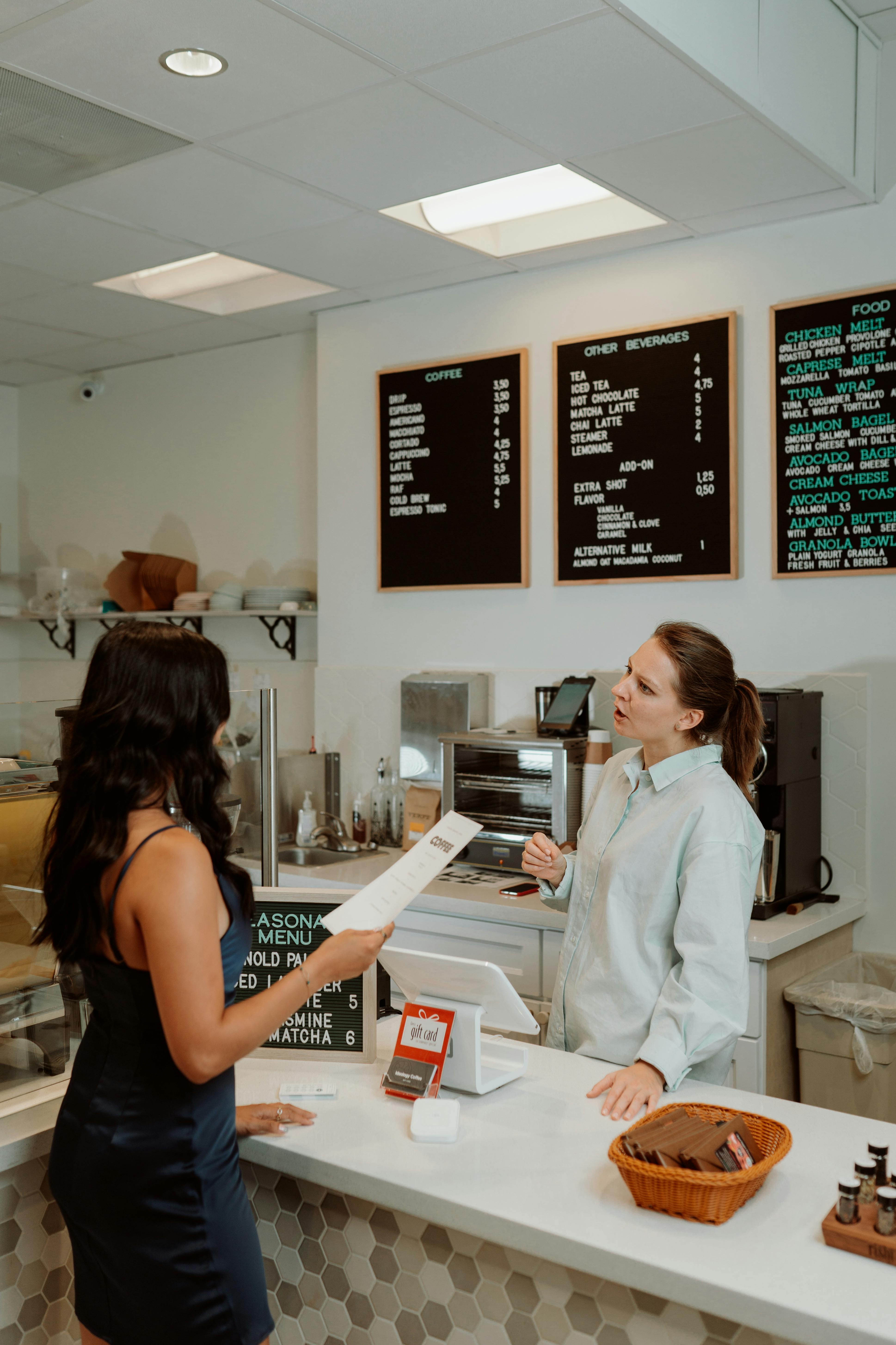 Cheerful black waitress standing at counter · Free Stock Photo