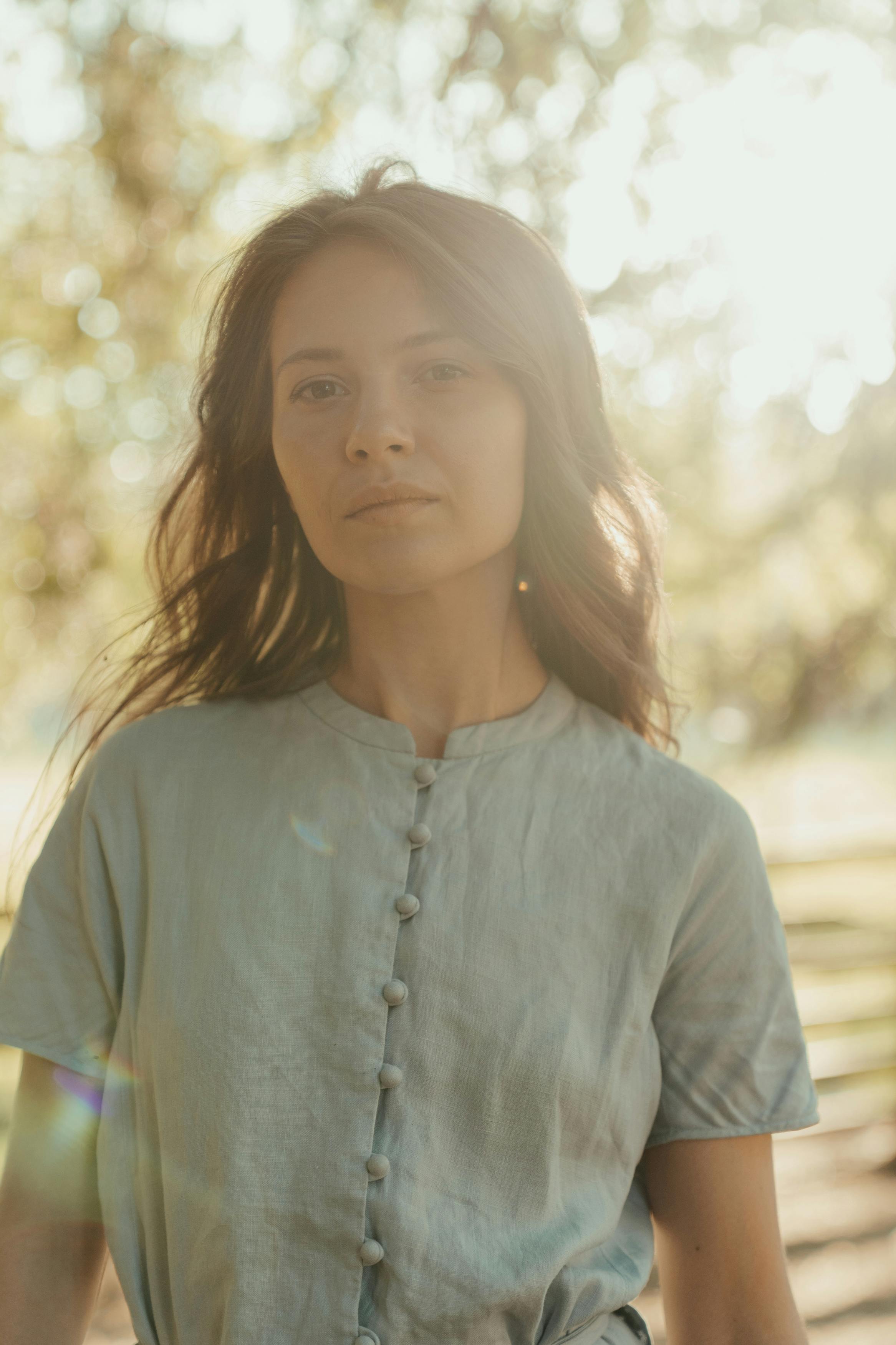 Woman In White Long Sleeve Shirt Sitting On Green Grass Field · Free