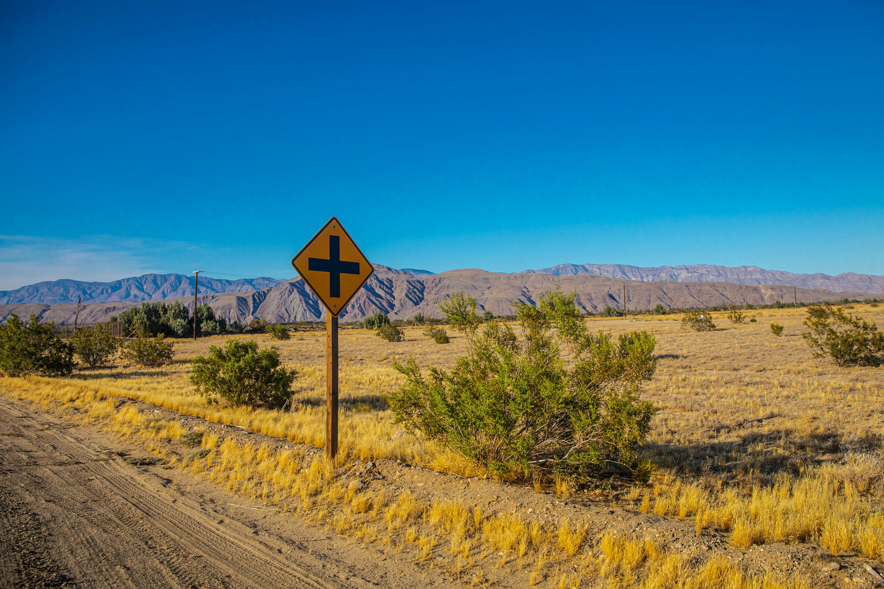 A Yellow and Black Cross Road Ahead Sign · Free Stock Photo
