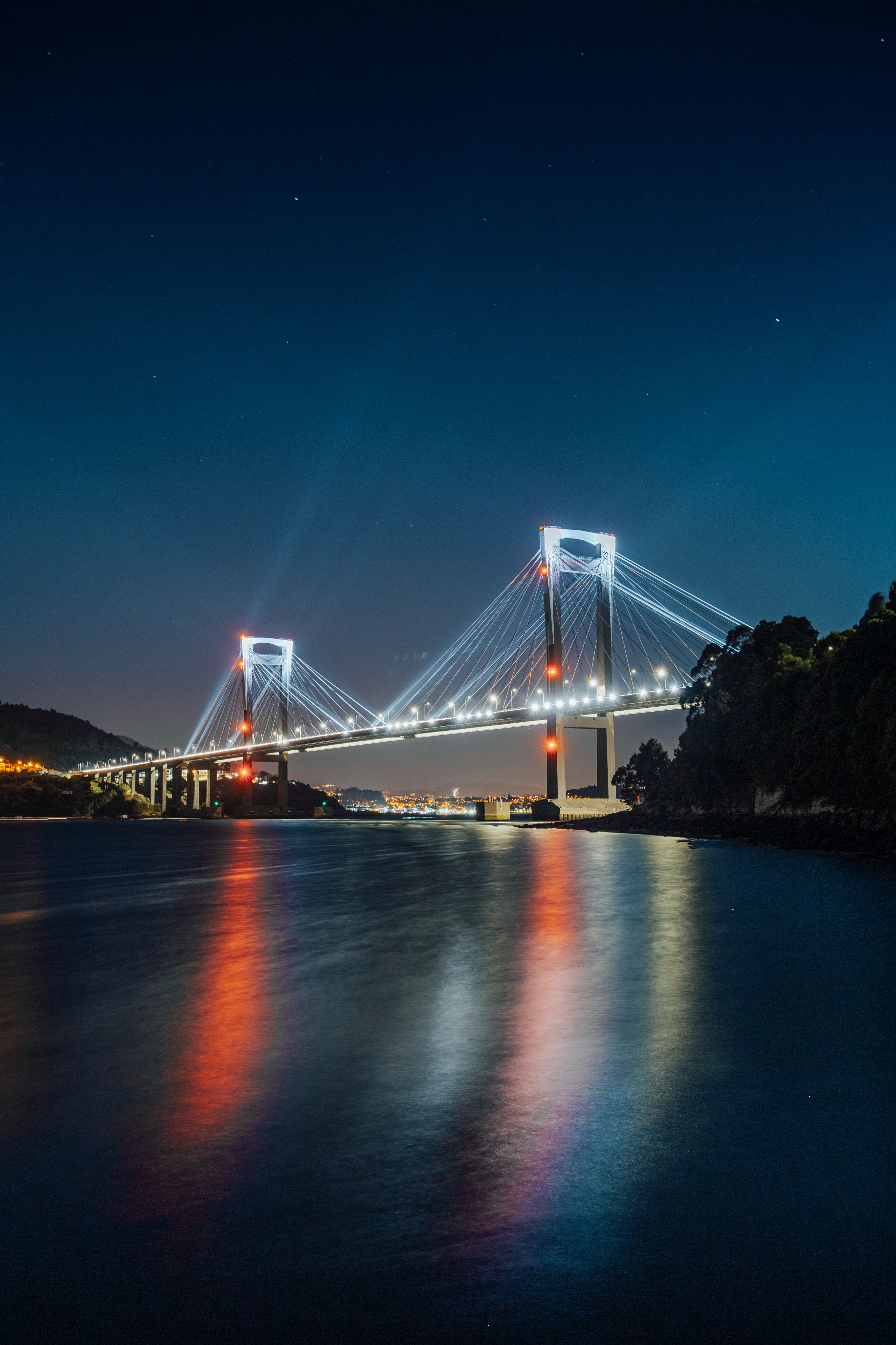 Modern bridge with shiny lights over river in darkness · Free Stock Photo