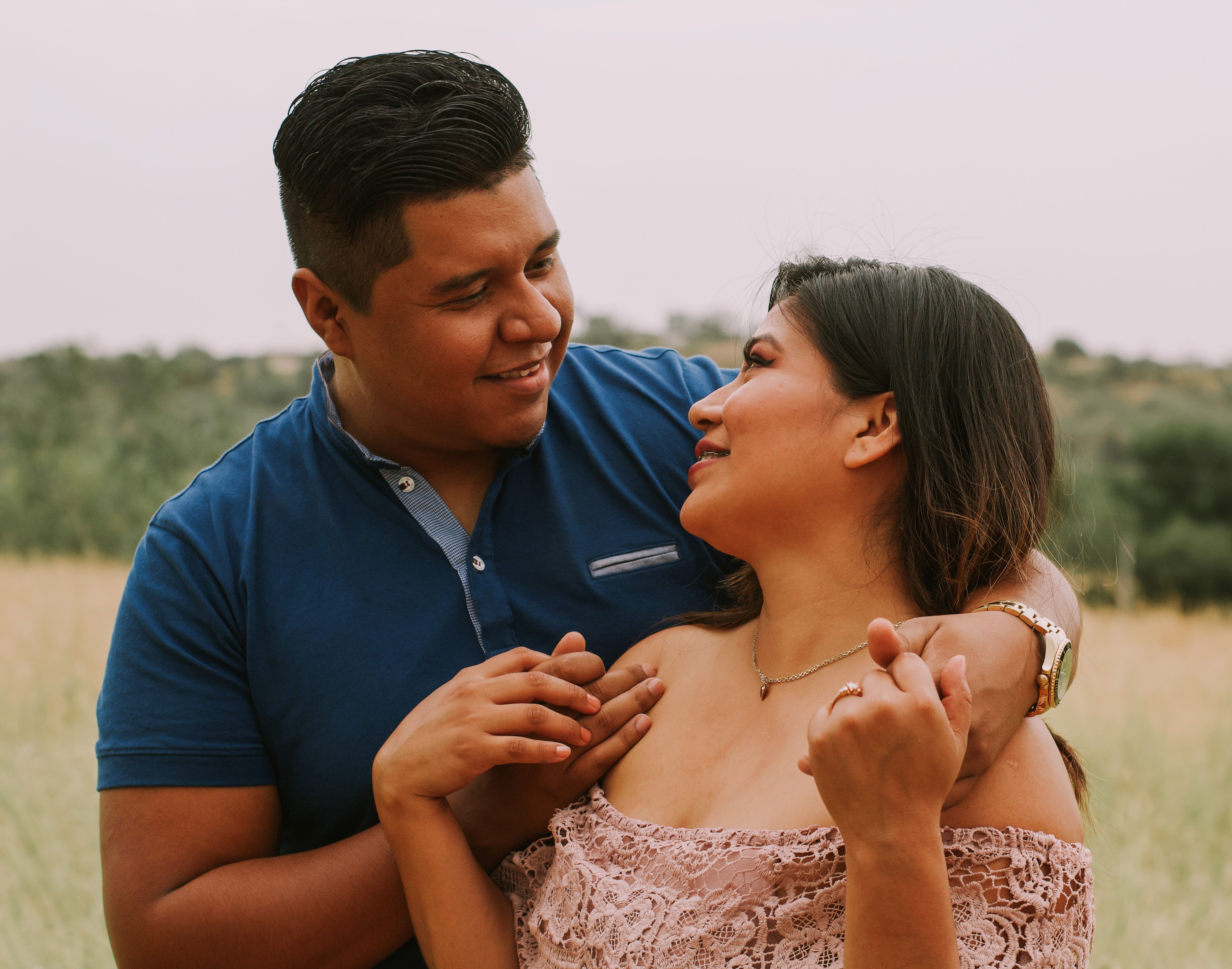 Loving Hispanic couple hugging near wooden wall · Free Stock Photo