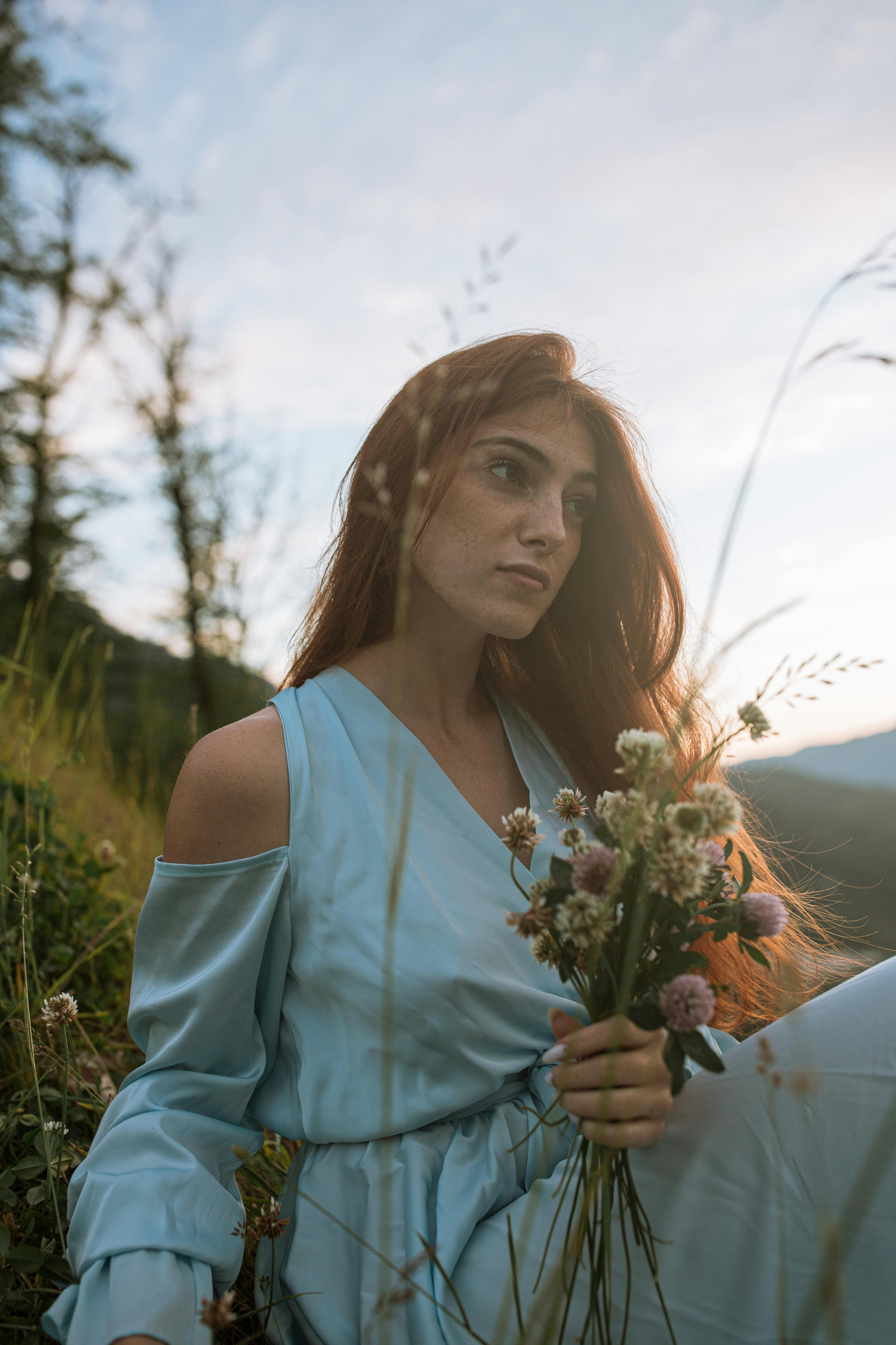 Woman in Light Blue Dress Holding Bouquet of Flowers · Free Stock Photo
