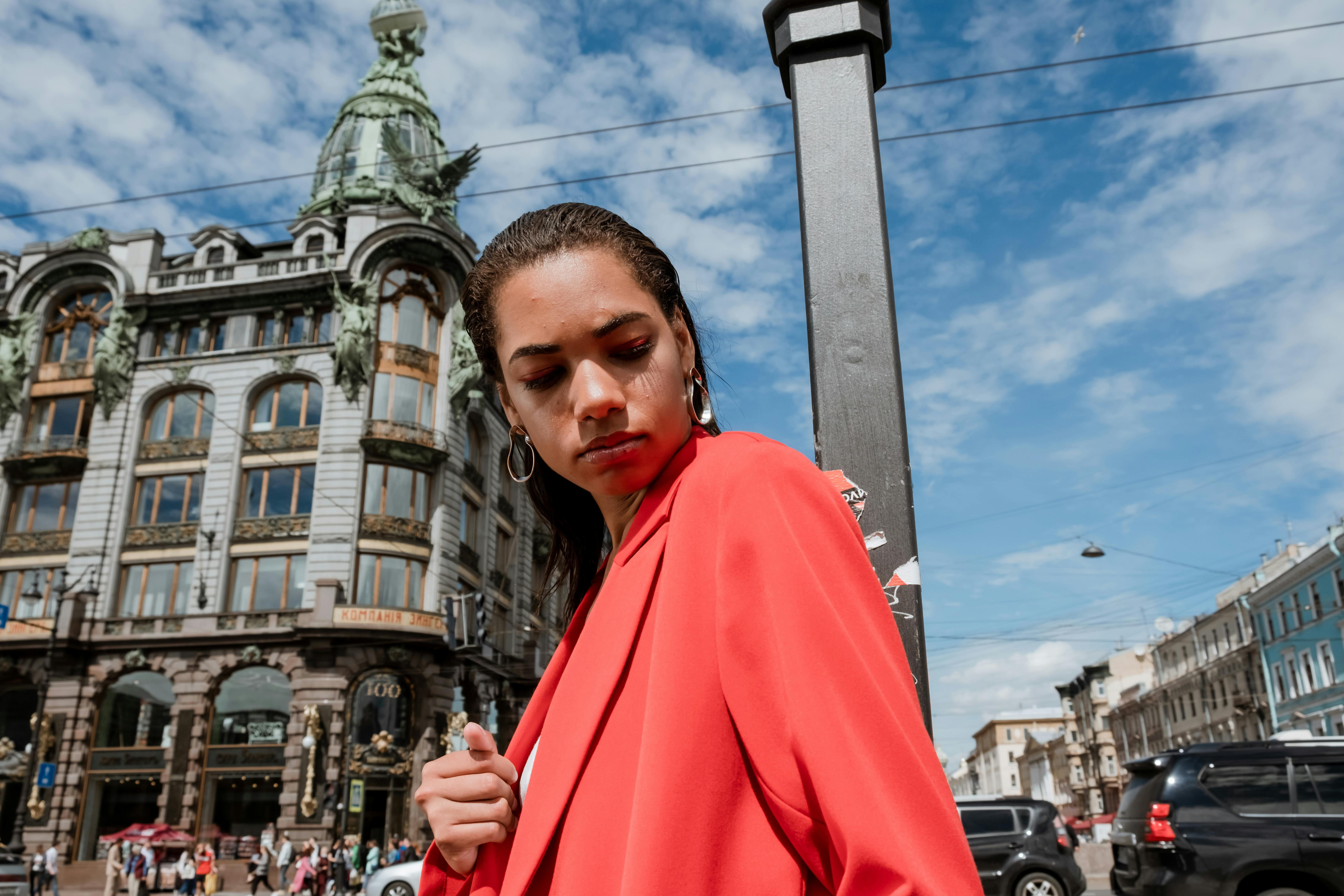 Woman in Red Robe Standing Near Gray Concrete Building · Free Stock Photo