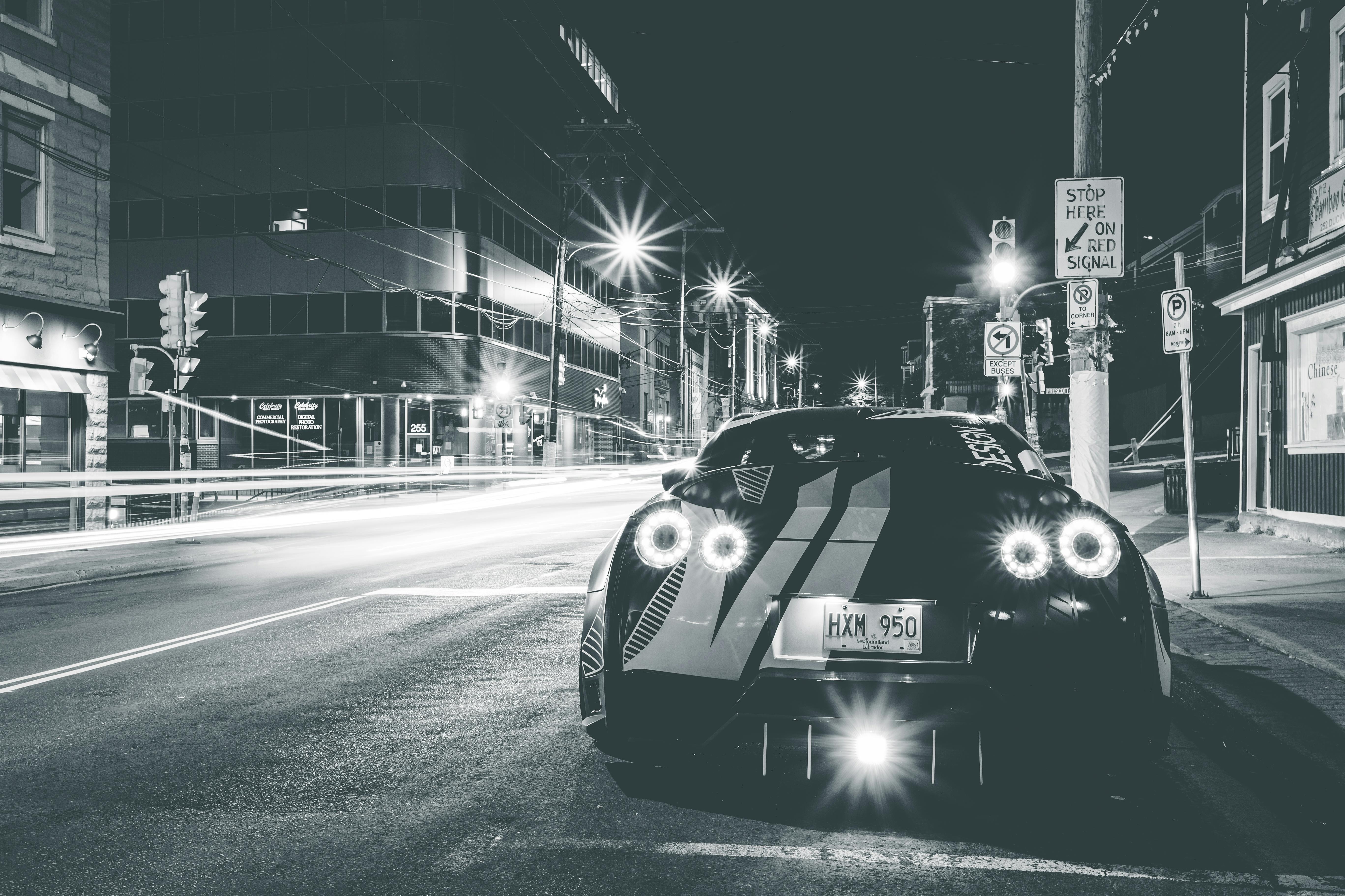 Unrecognizable men in glowing Halloween masks driving car at night ...