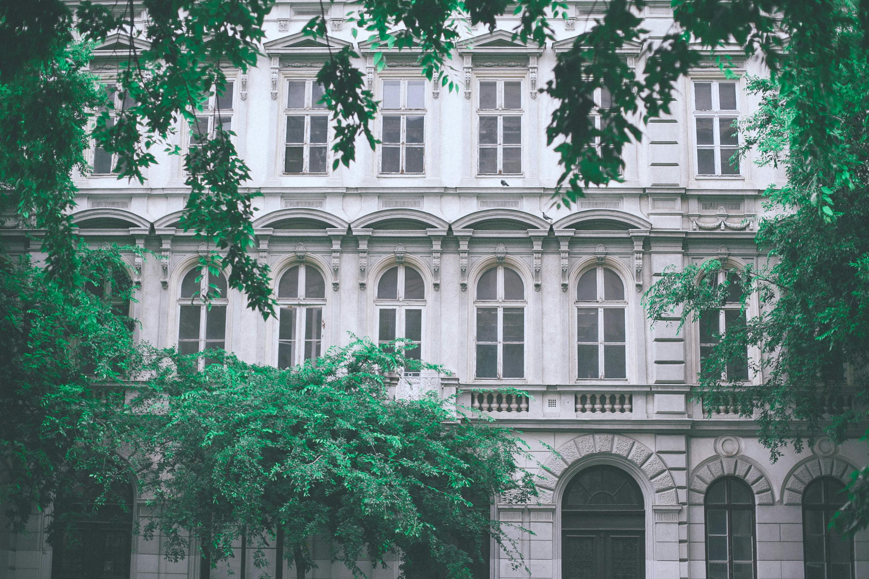 Old building with balconies and arched passage · Free Stock Photo
