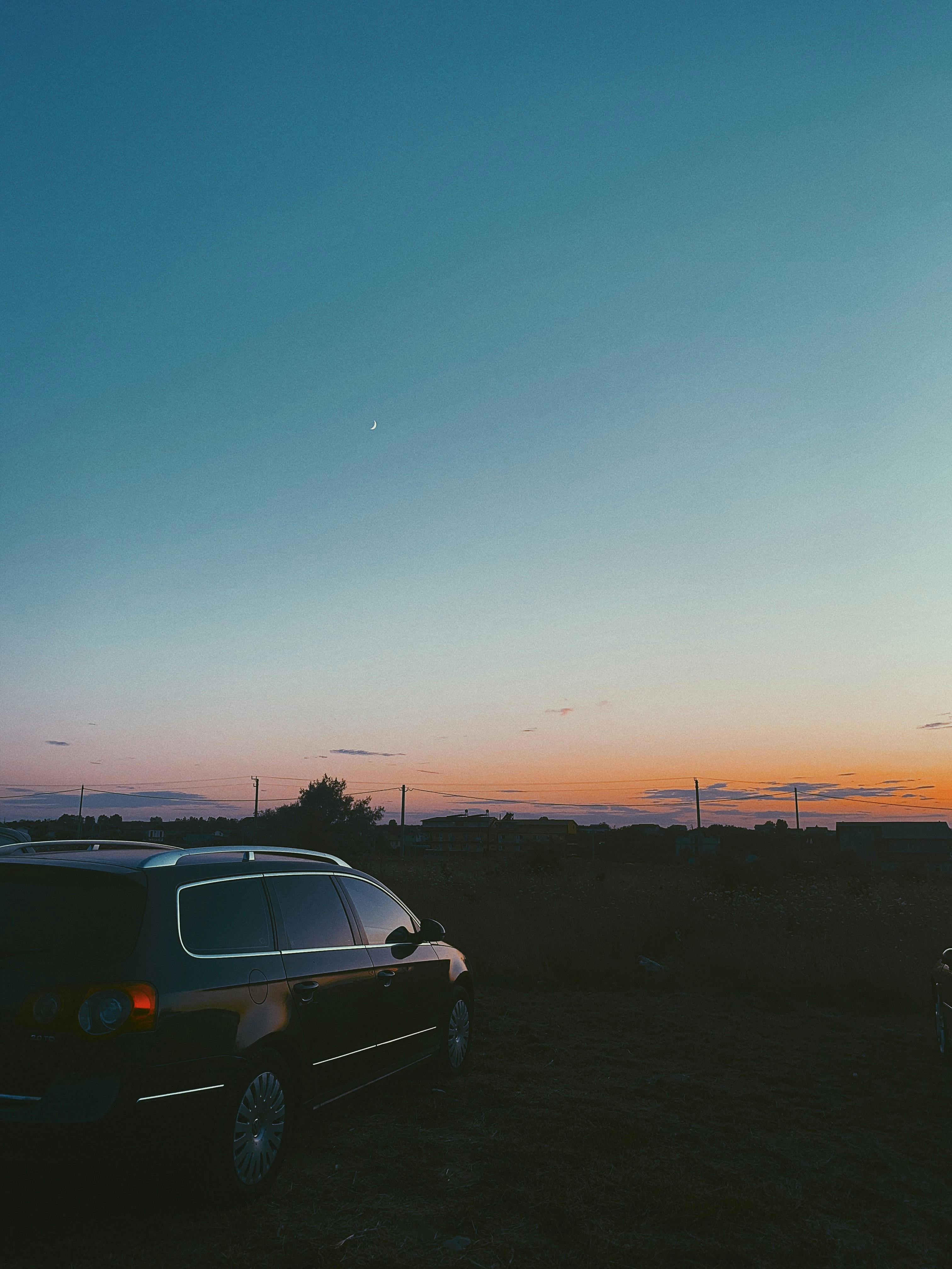 Parked car under colorful sky at sunset · Free Stock Photo