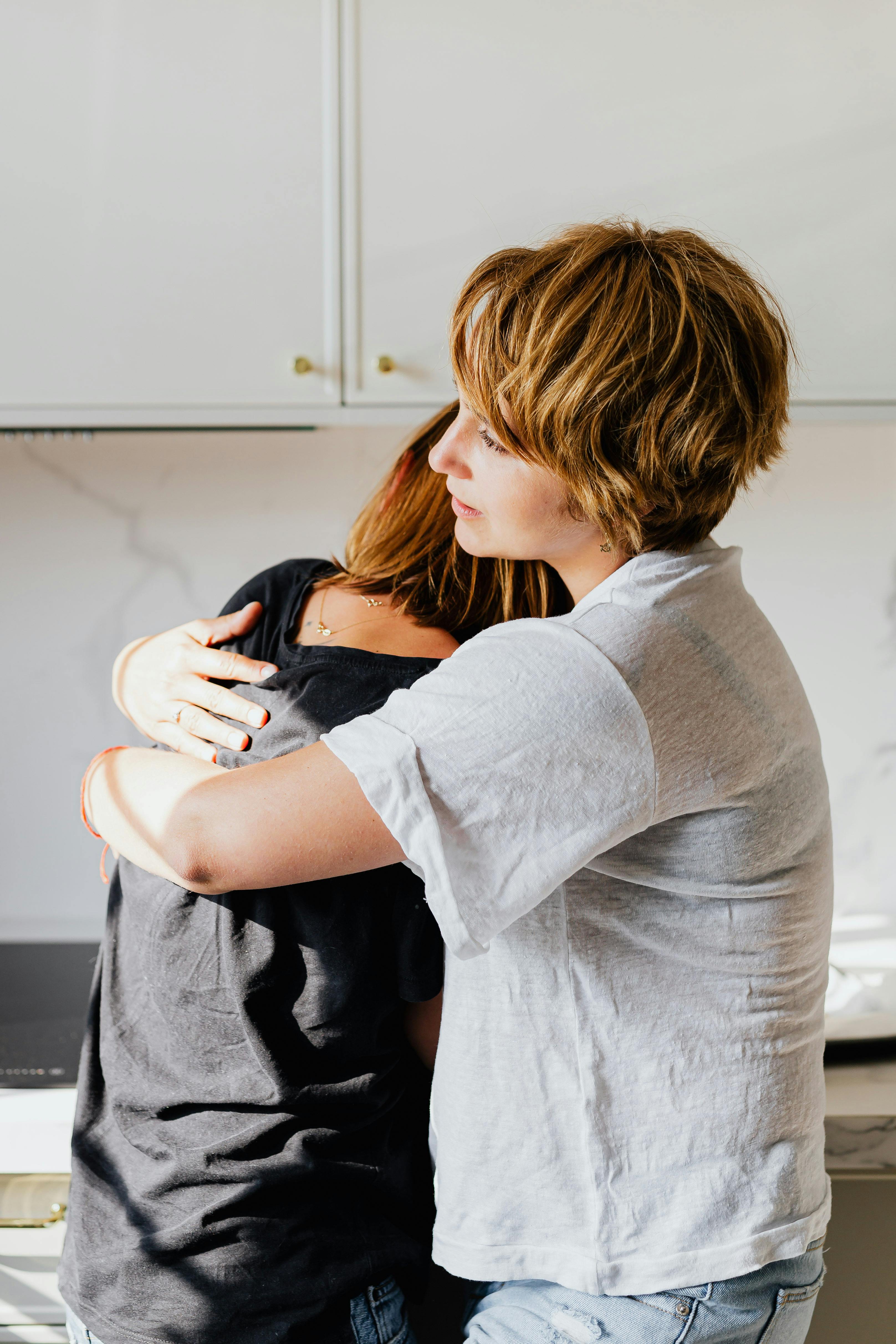 Woman in Gray Shirt Embracing a Woman in Black Shirt · Free Stock Photo