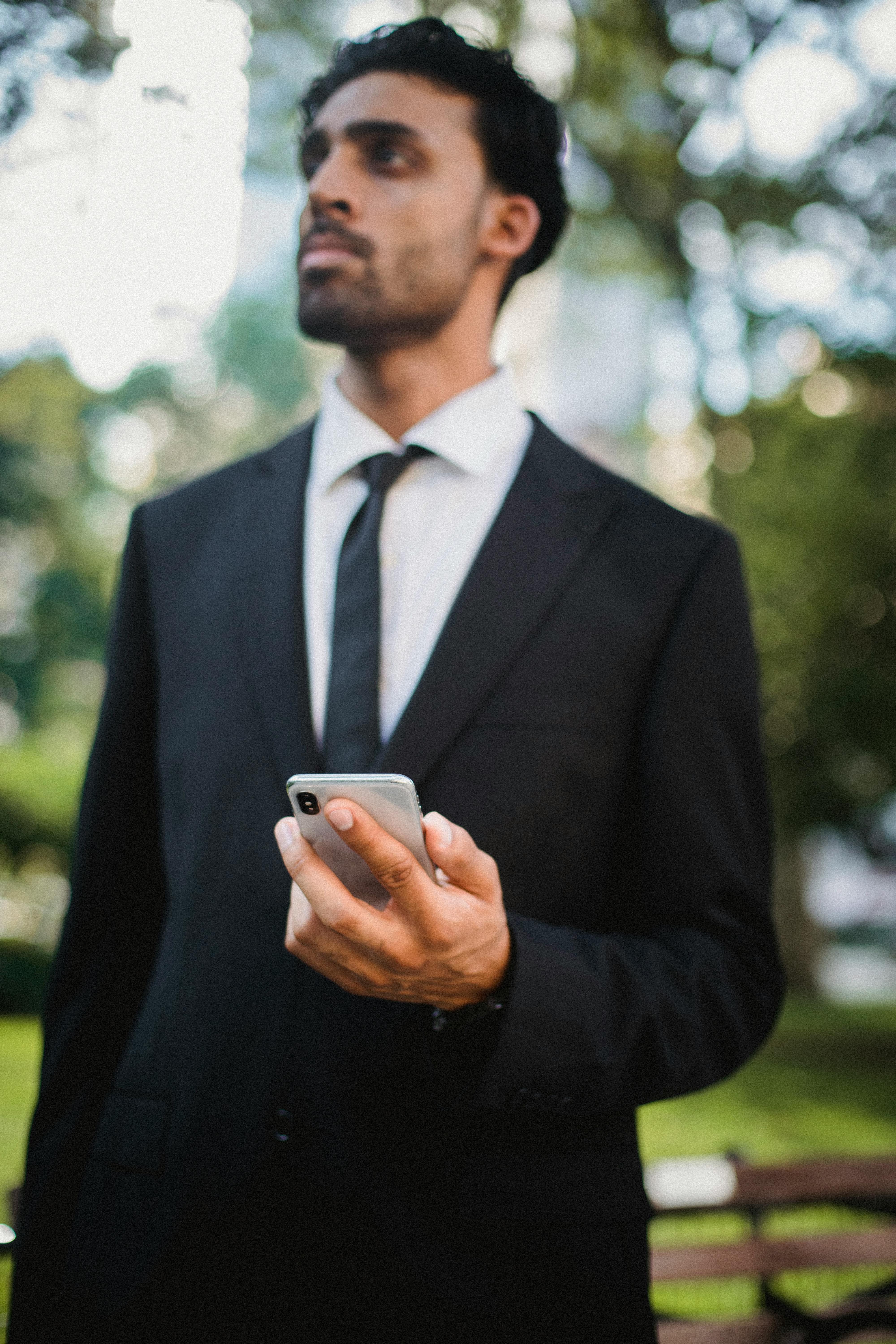 A Man in a Black Suit Holding His Phone · Free Stock Photo