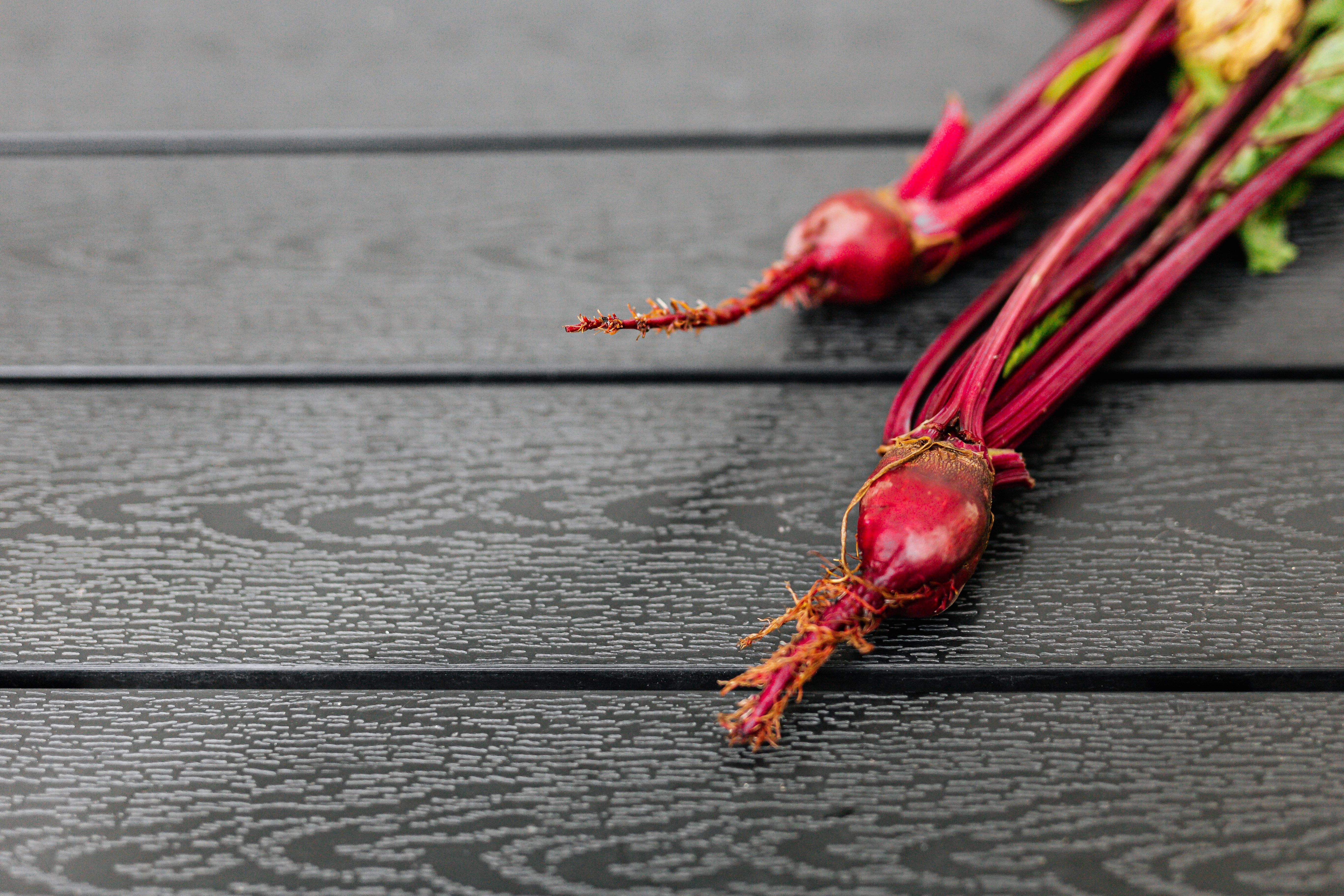Close-Up Shot or Red Beetroot on Brown Wooden Table · Free Stock Photo
