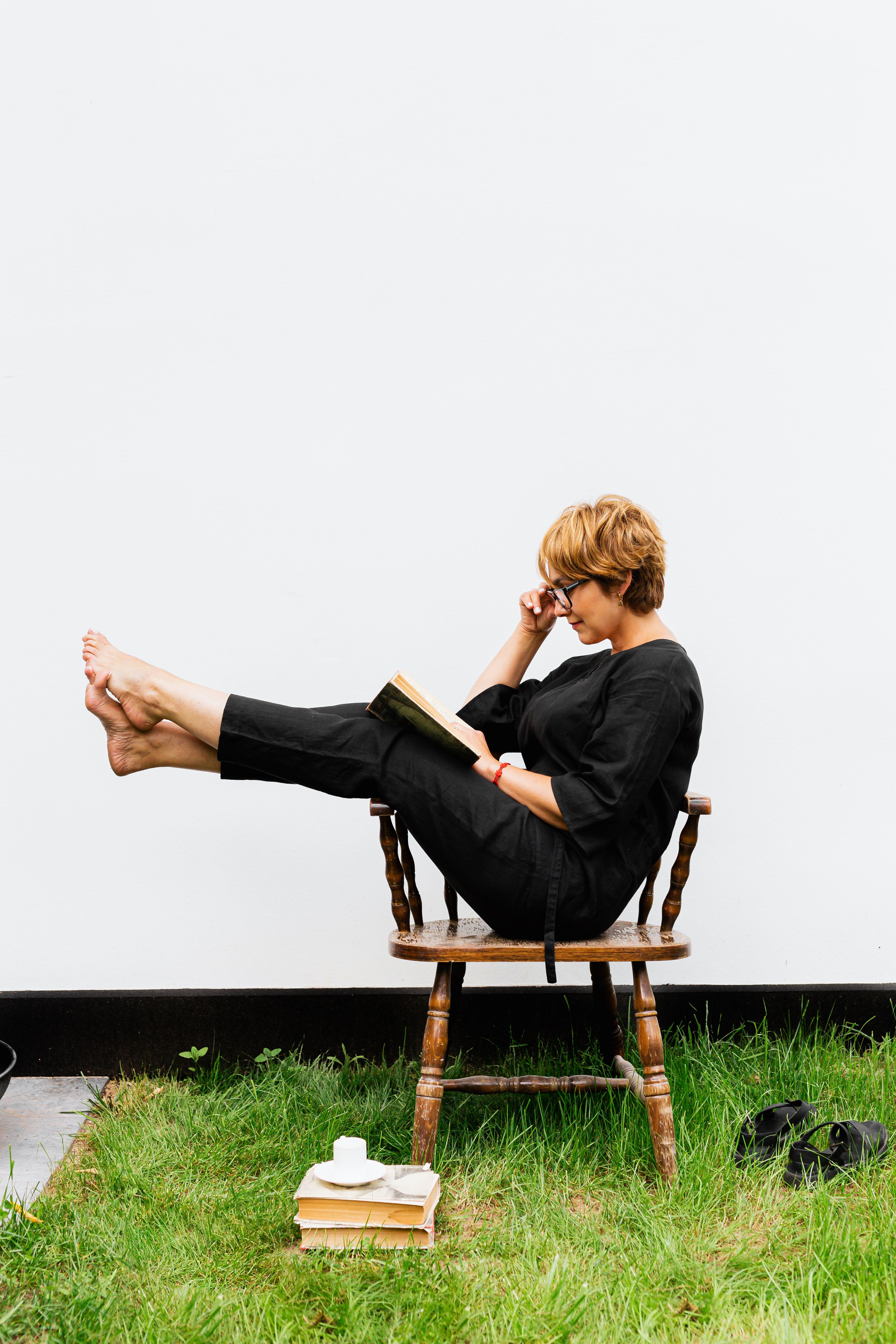 Photo of a Woman Reading on a Chair · Free Stock Photo