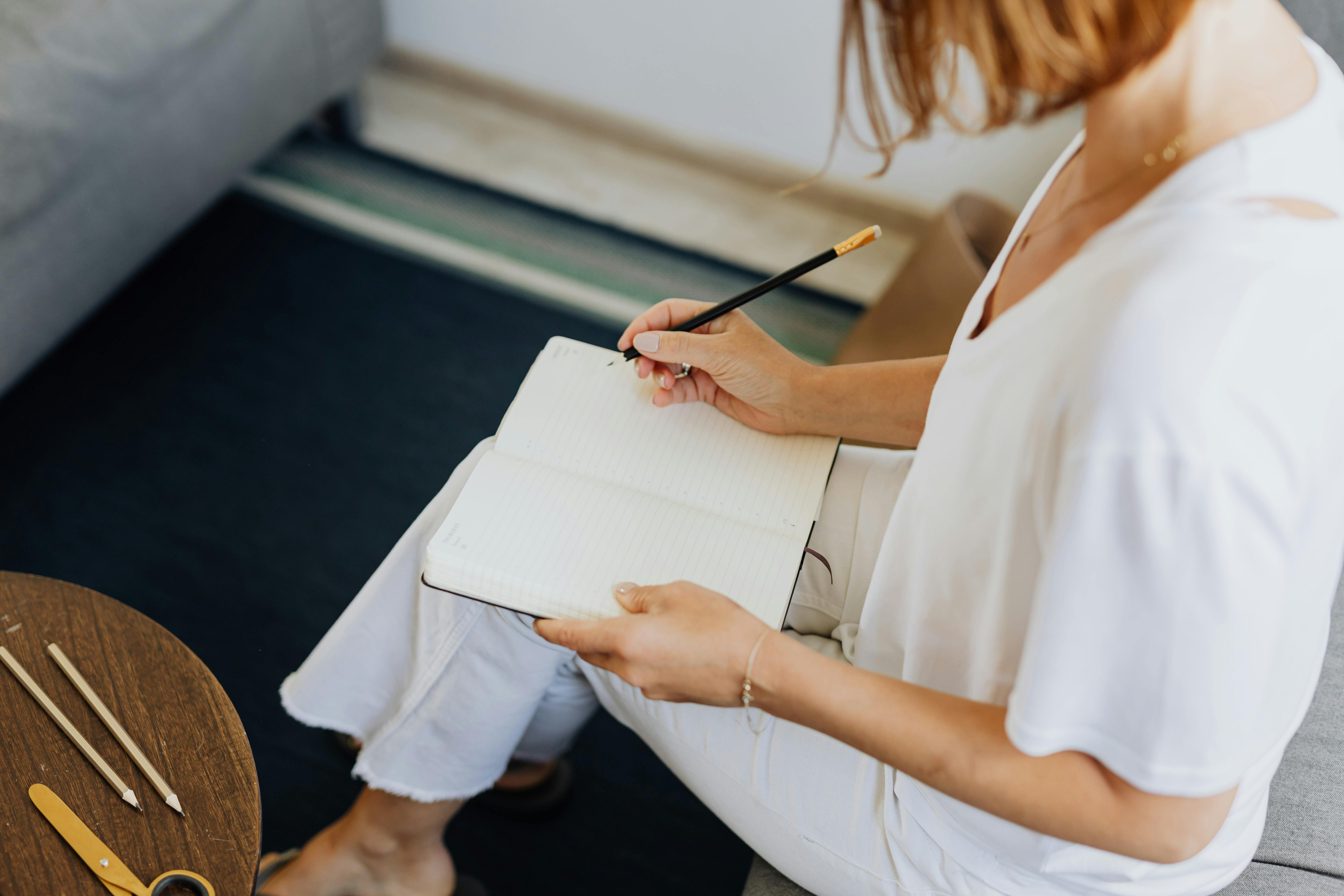 A Person Holding a Pencil and a Notebook · Free Stock Photo