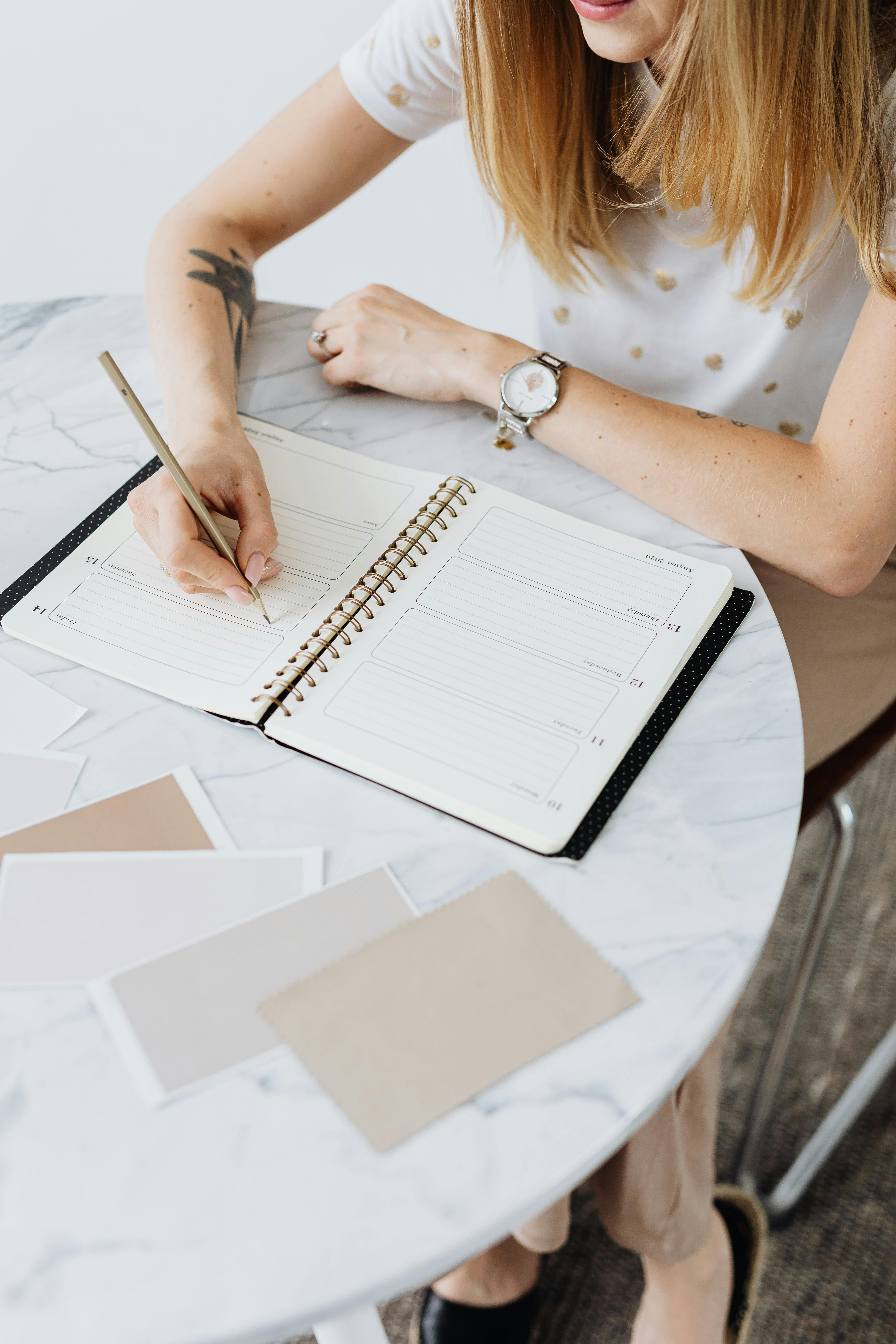 Close-up of Woman Writing in Planner · Free Stock Photo