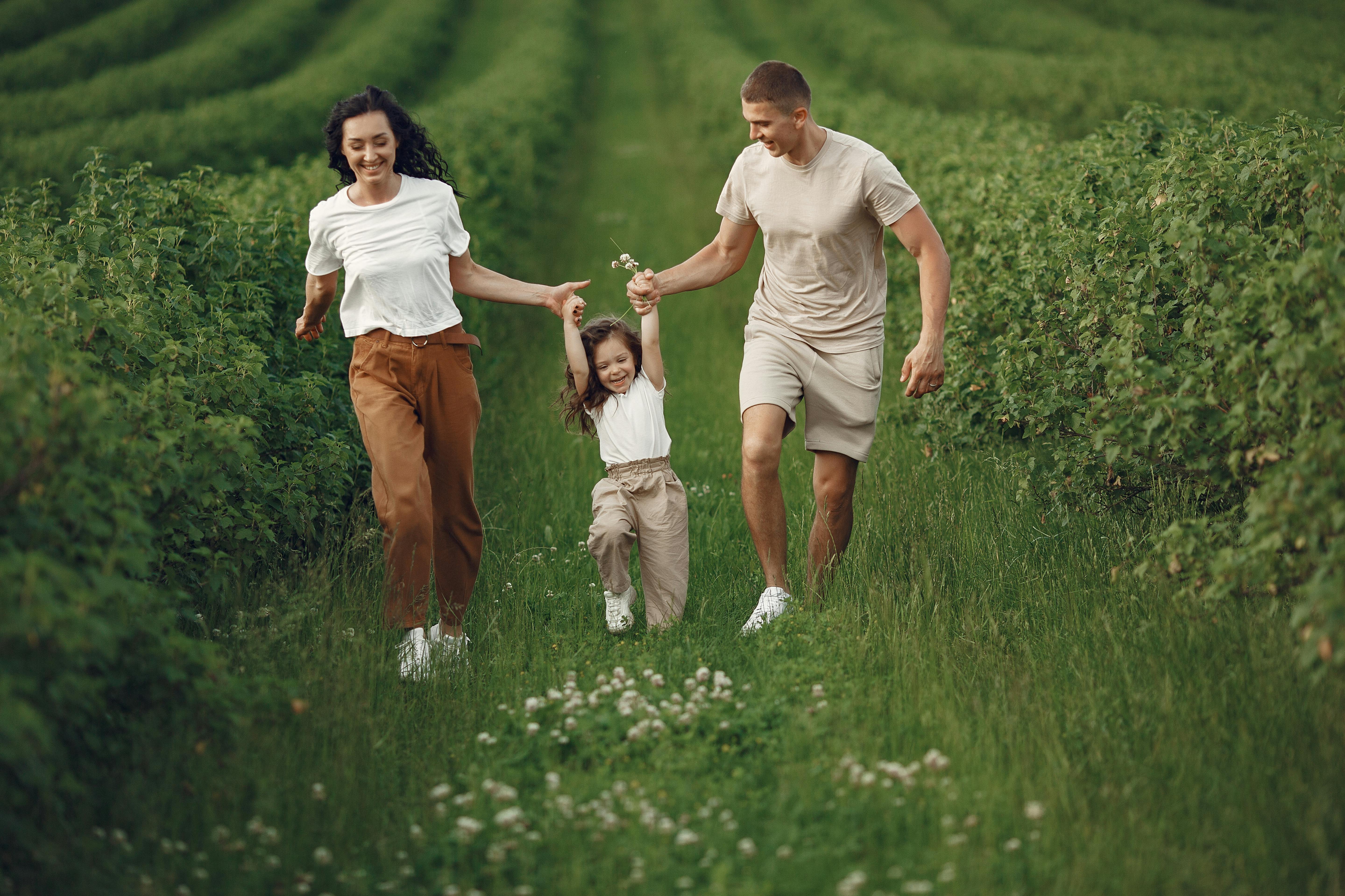 Family on Field Picking up Flowers · Free Stock Photo