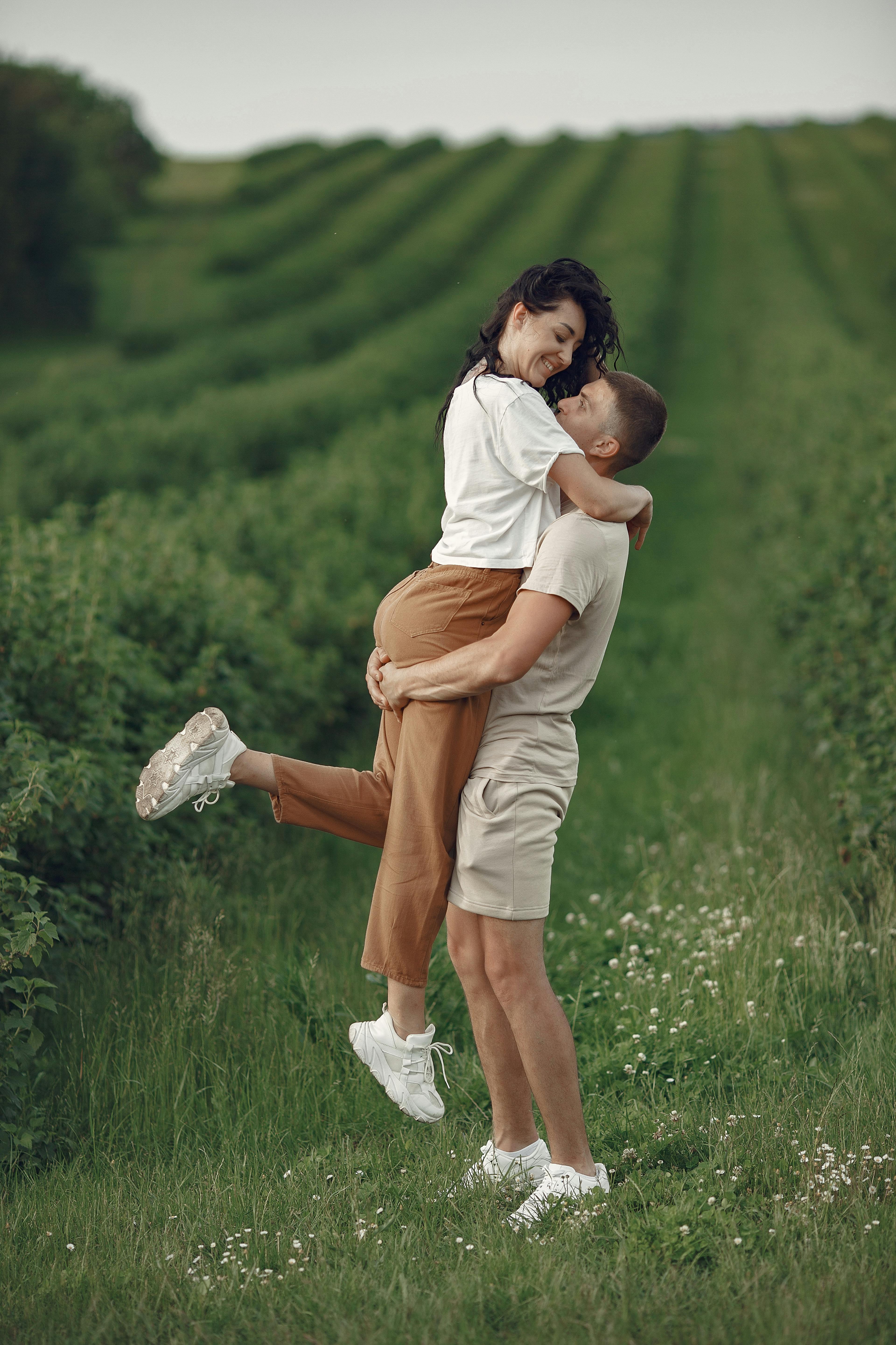 Man Picking Woman Up on Field · Free Stock Photo