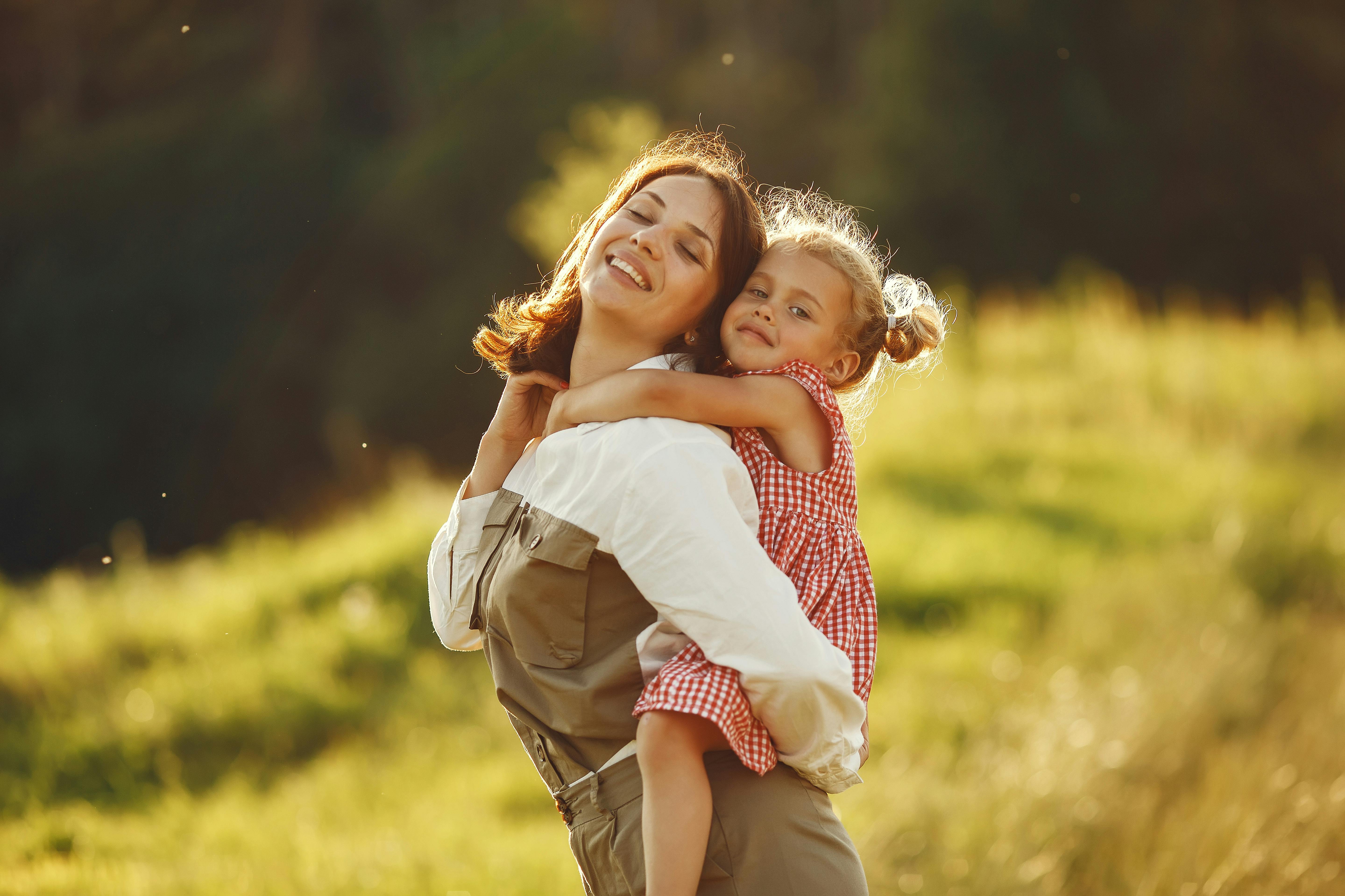 A Woman Giving a Piggy Back Ride to her Daughter · Free Stock Photo