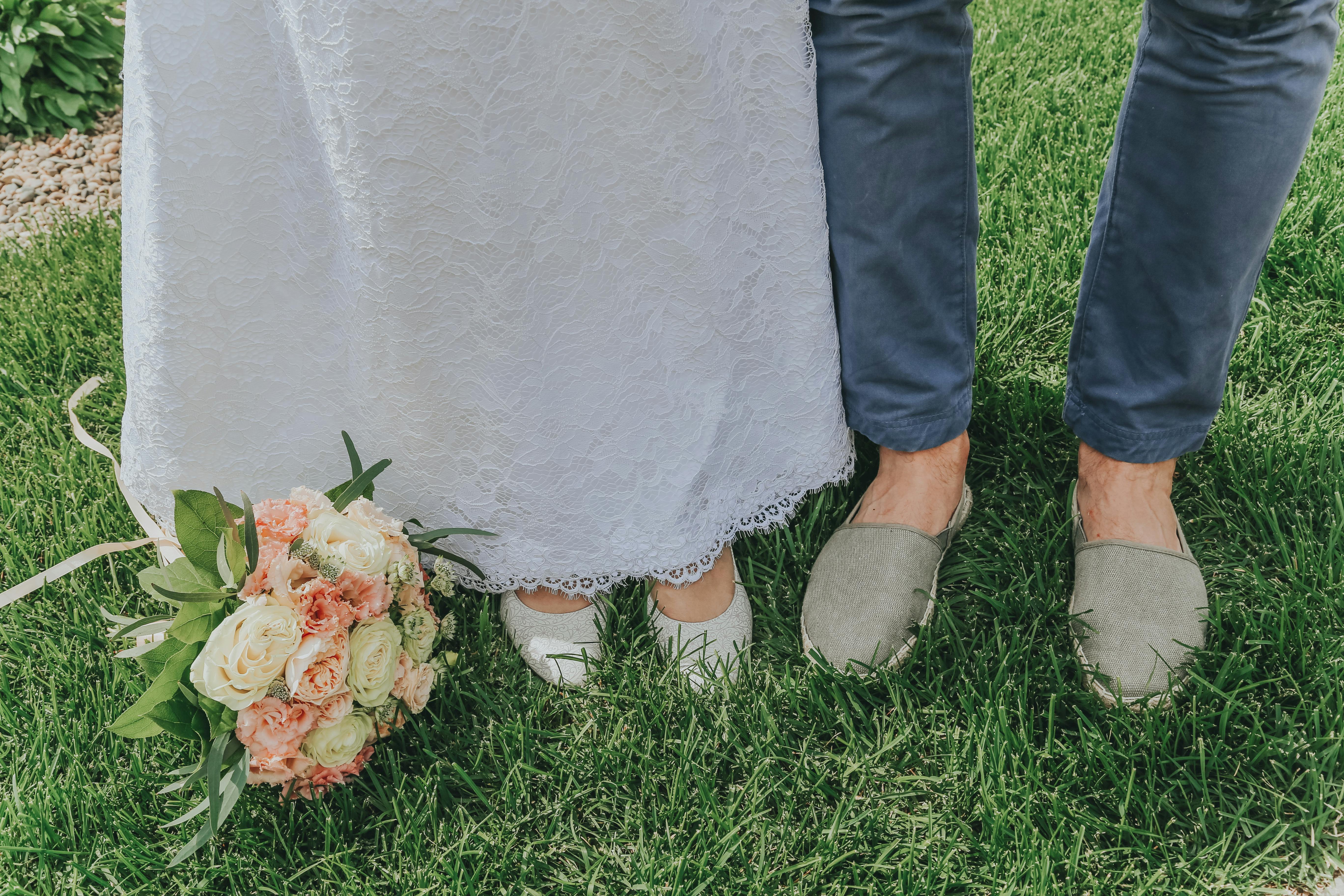 Faceless newly married couple on grass · Free Stock Photo