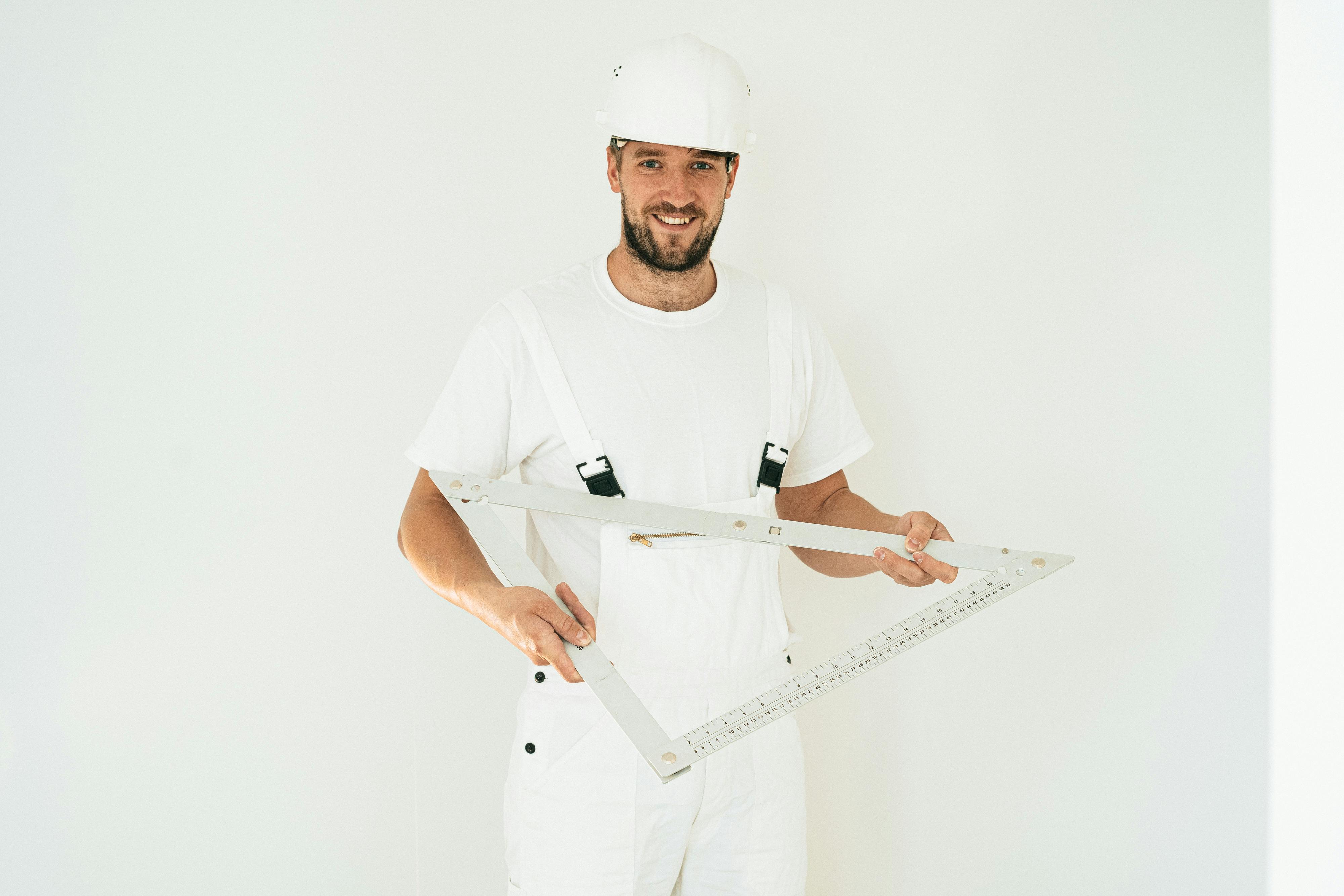An Engineer Holding a Spirit Level Against a Wall · Free Stock Photo