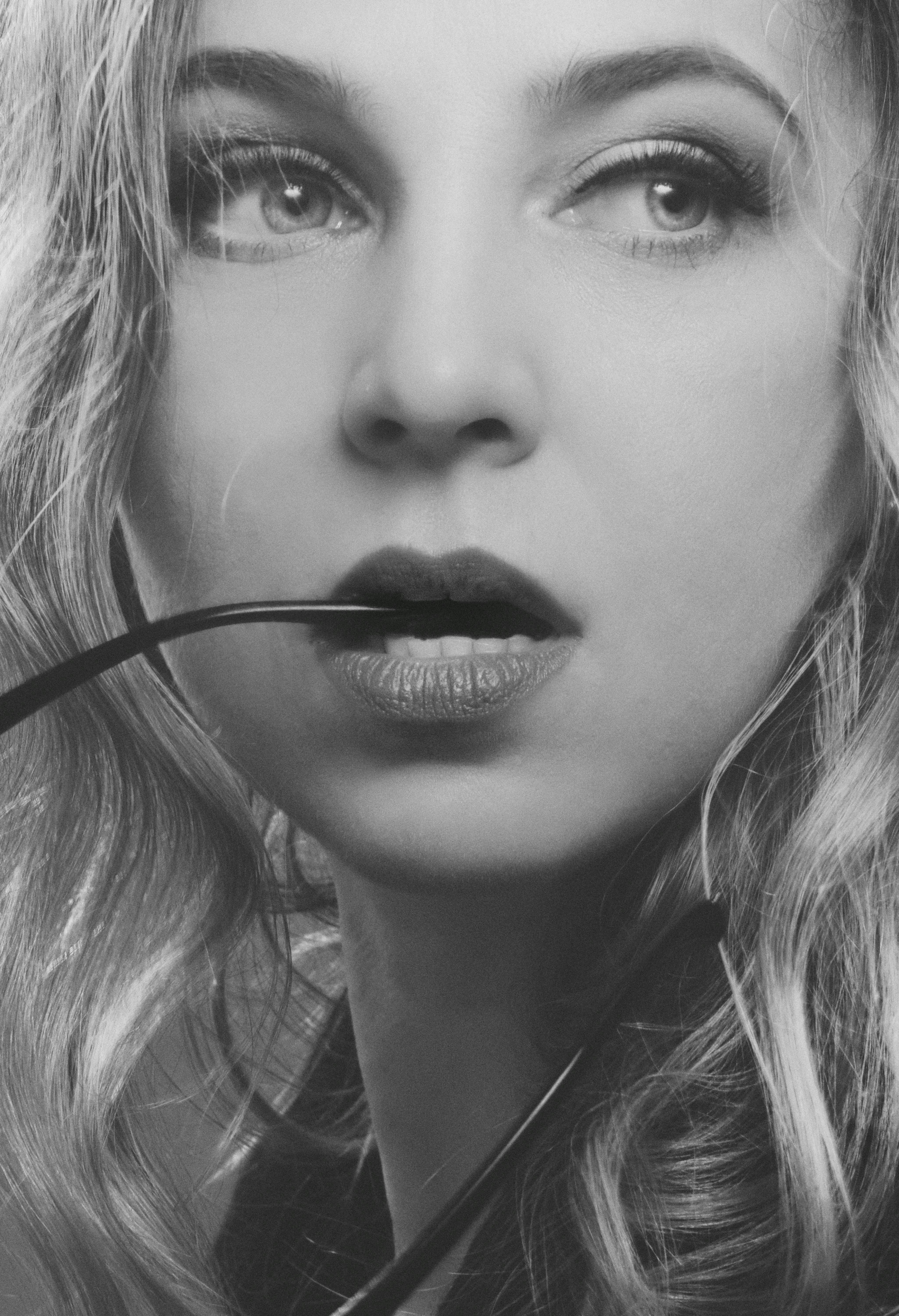 Grayscale Photo of a Woman Biting Sunglasses · Free Stock Photo