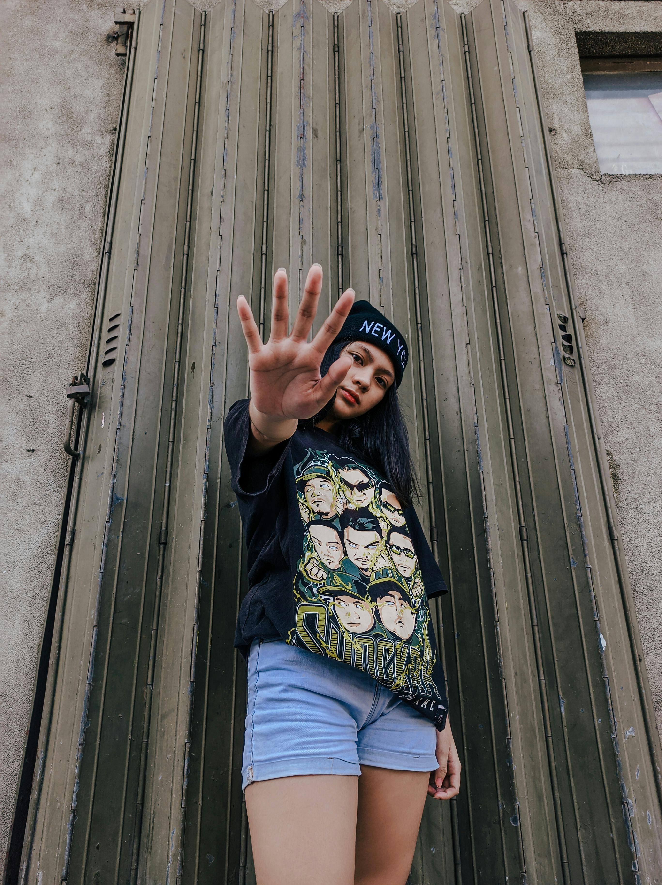 Raised female hand against wall · Free Stock Photo