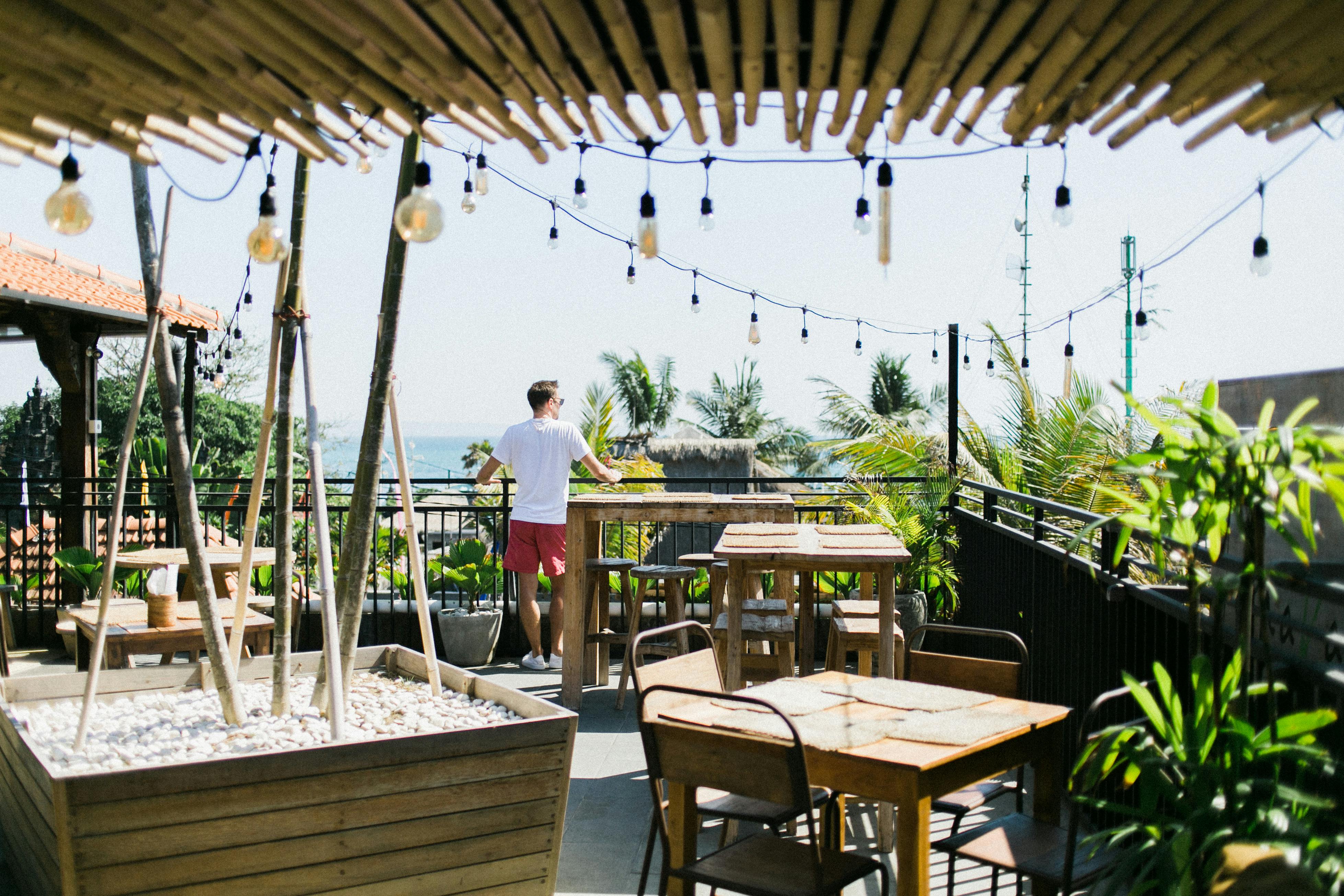 Faceless man leaning on railing in cafe · Free Stock Photo