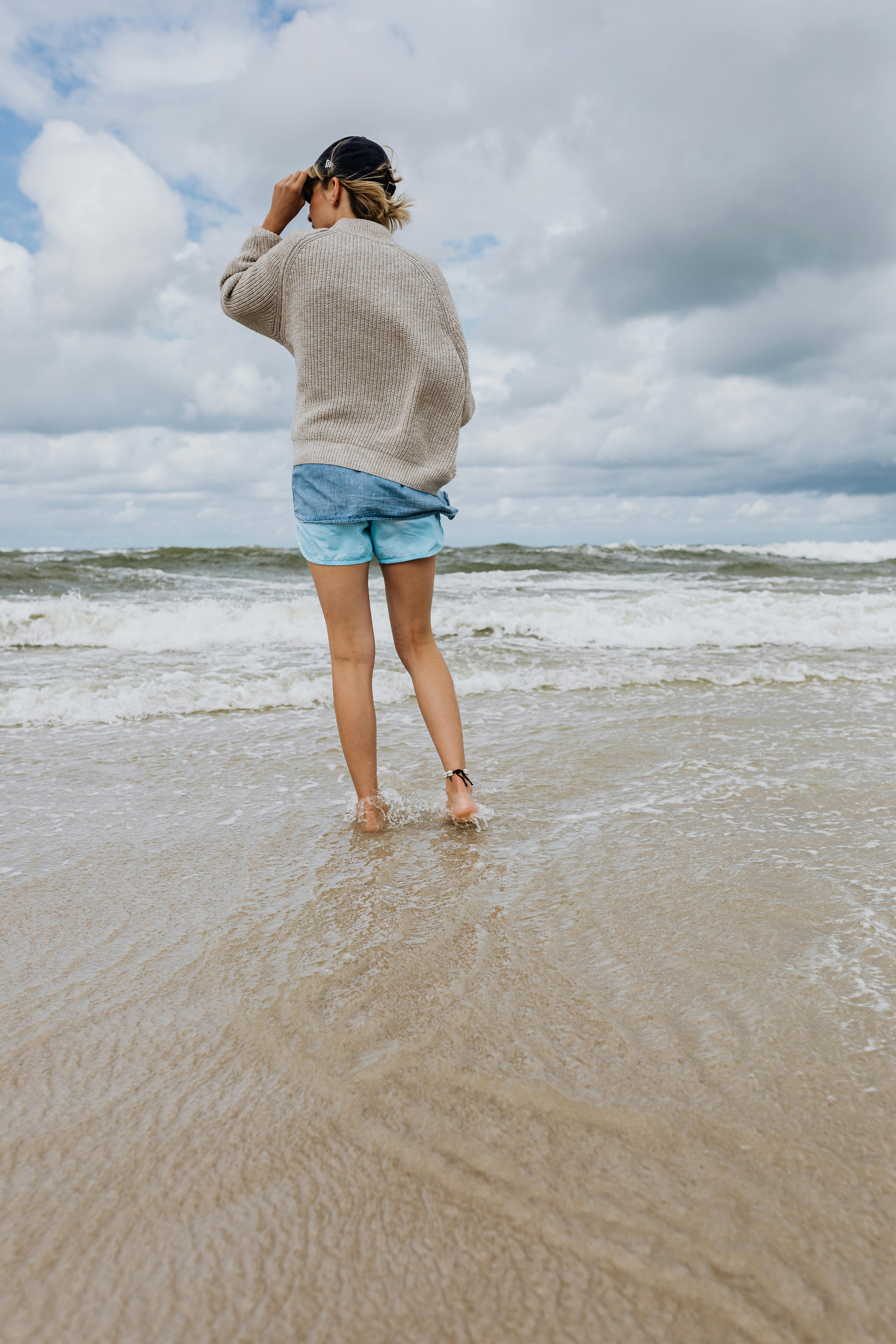 Back View of Woman Standing on Beach Shore · Free Stock Photo
