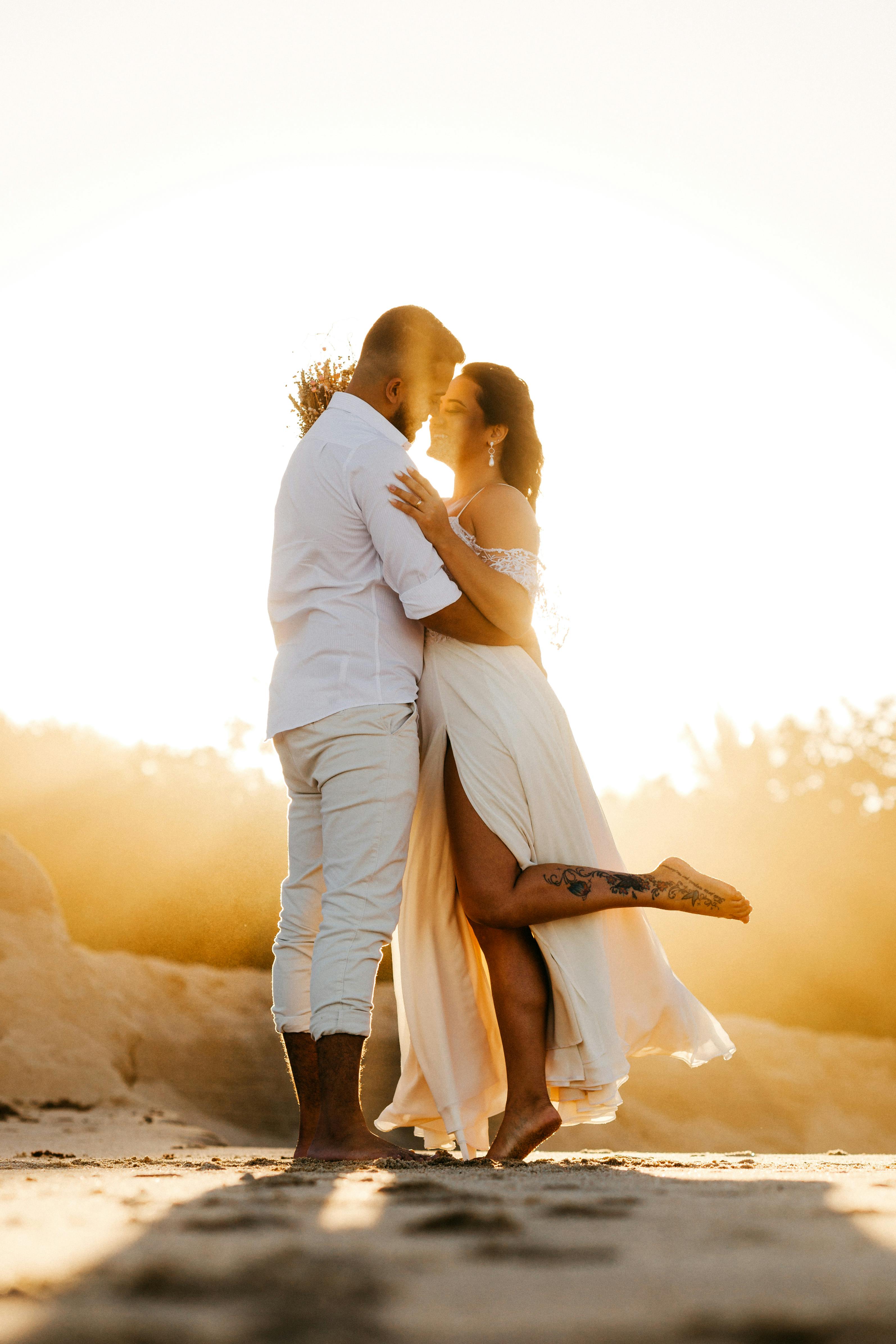 Romantic couple cuddling and enjoying sunset on beach · Free Stock Photo