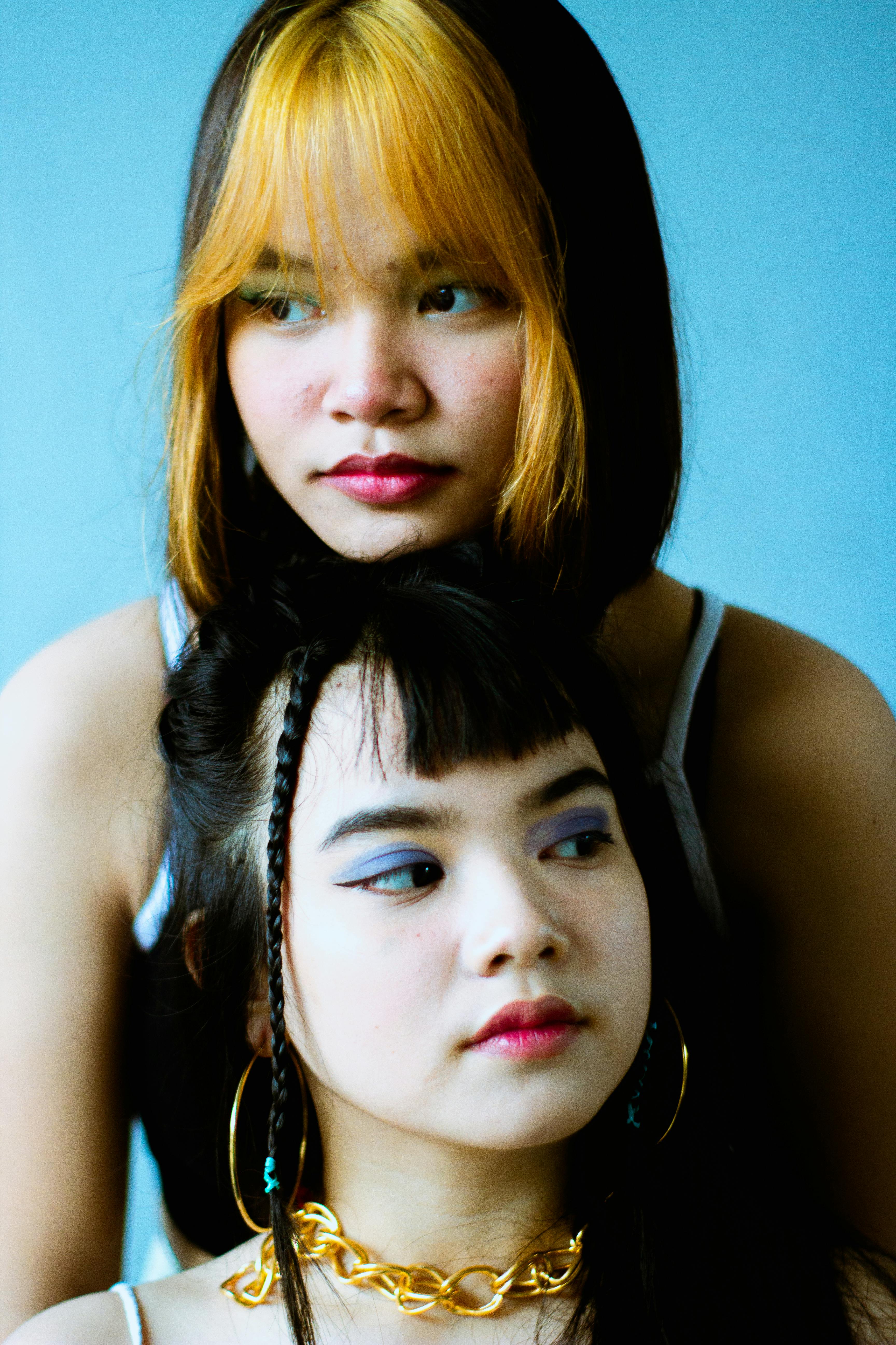 Two Women Wearing Identical Clothing and Accessories · Free Stock Photo