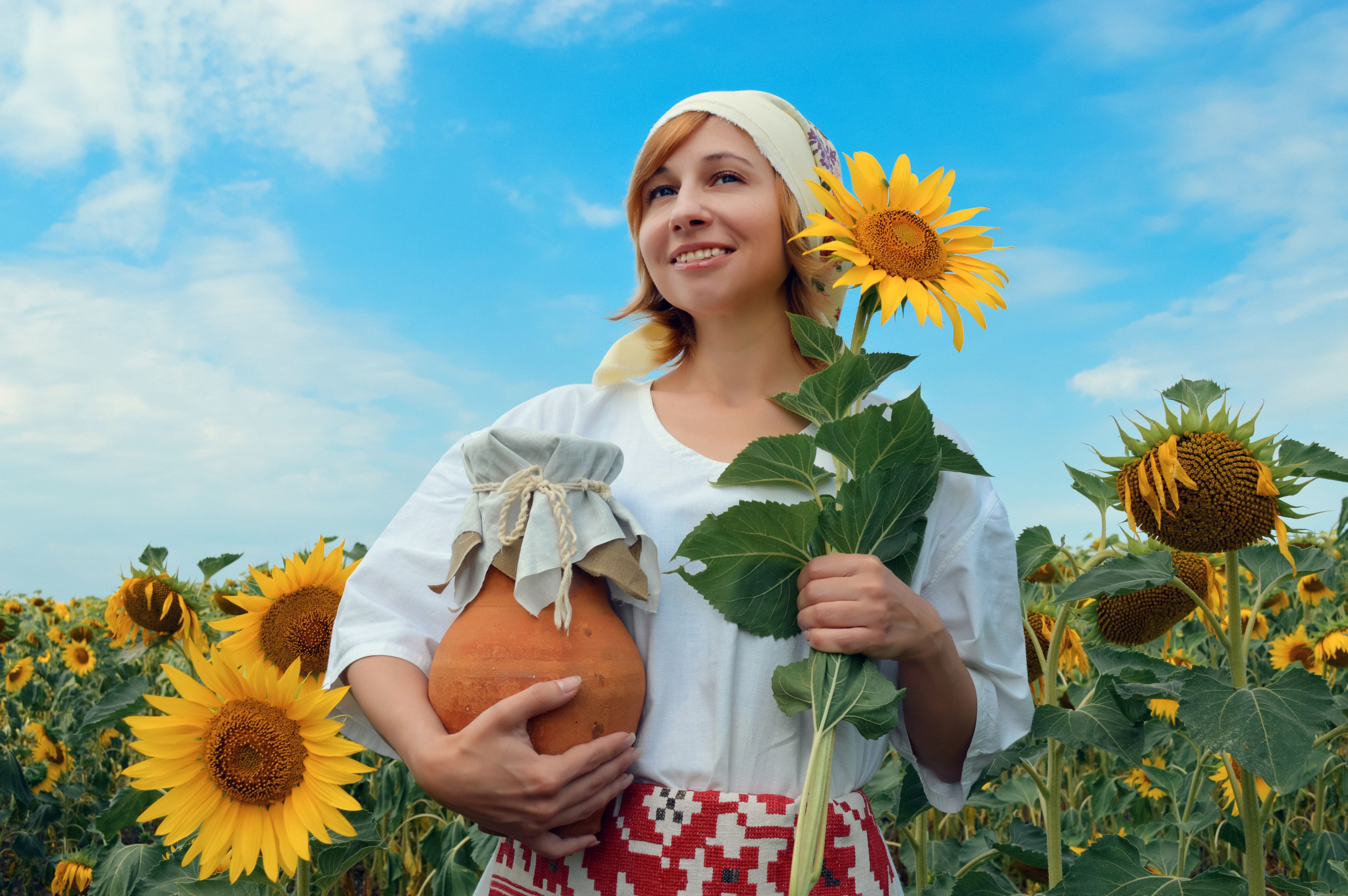 Young Slavic peasant in sunflower field · Free Stock Photo