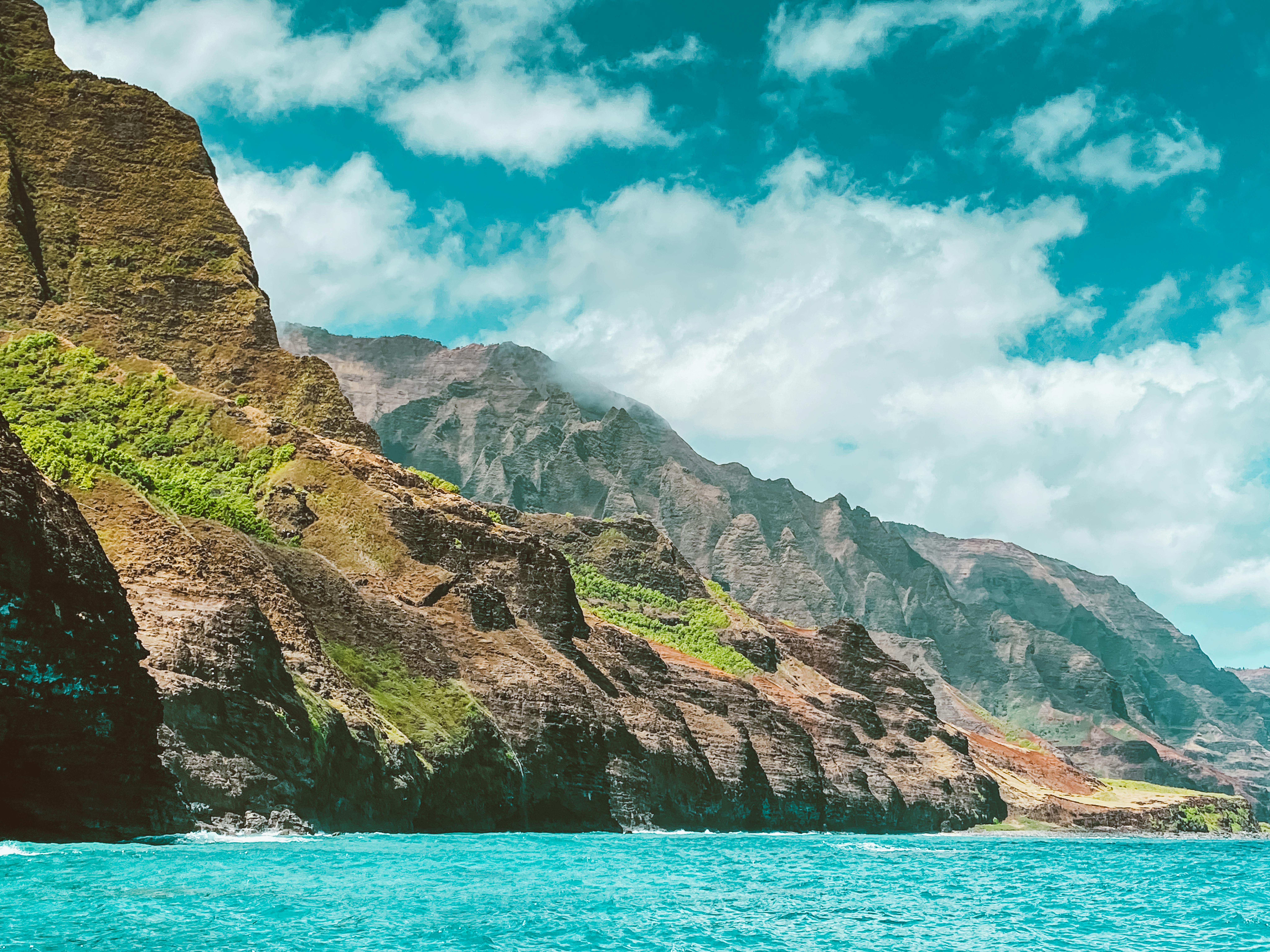 Cliff Mountain next to Turquoise Ocean Water · Free Stock Photo