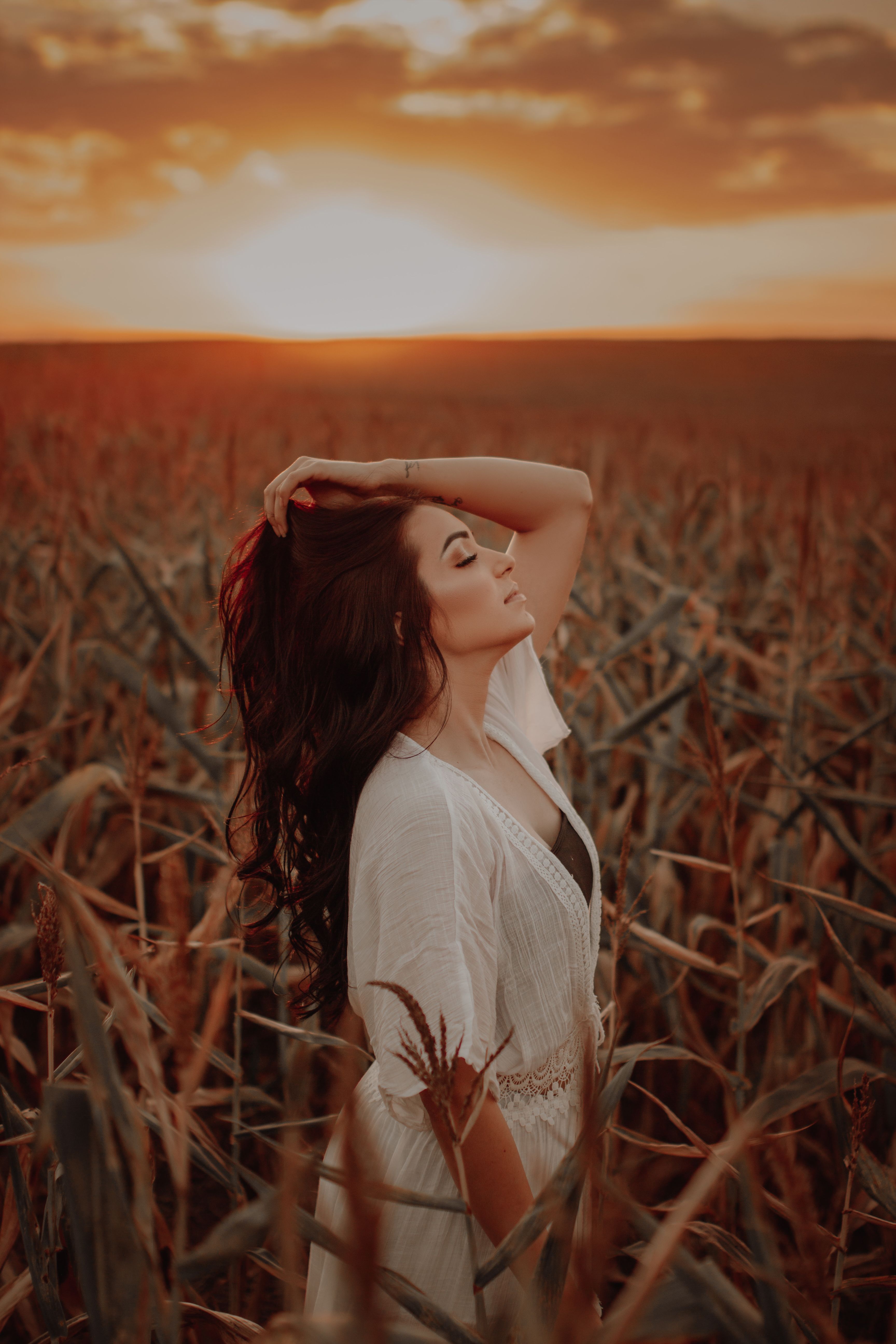 A Woman Standing on a Cropland with Her Eyes Closed · Free Stock Photo