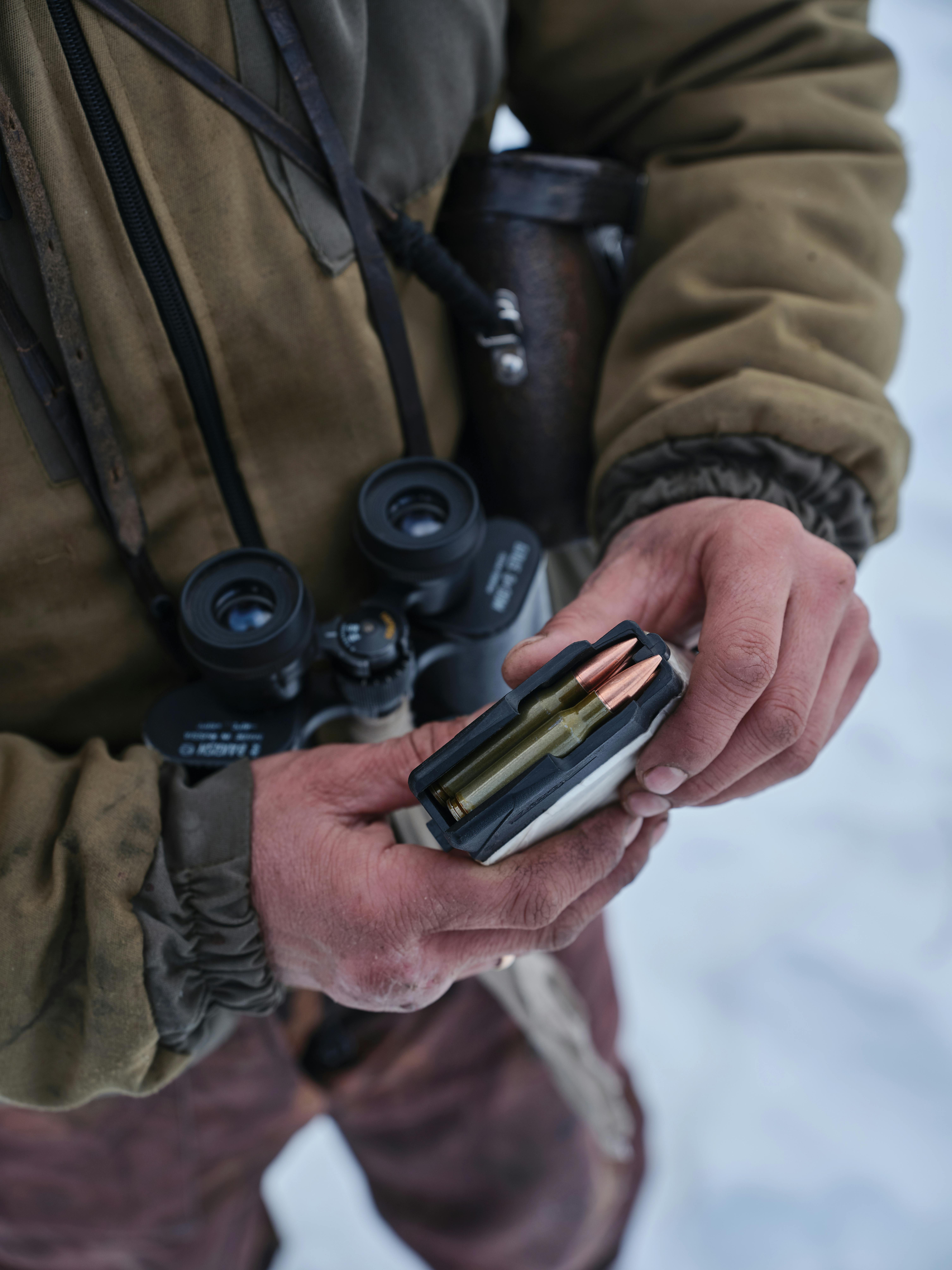 A Person Holding a Magazine with Bullets · Free Stock Photo
