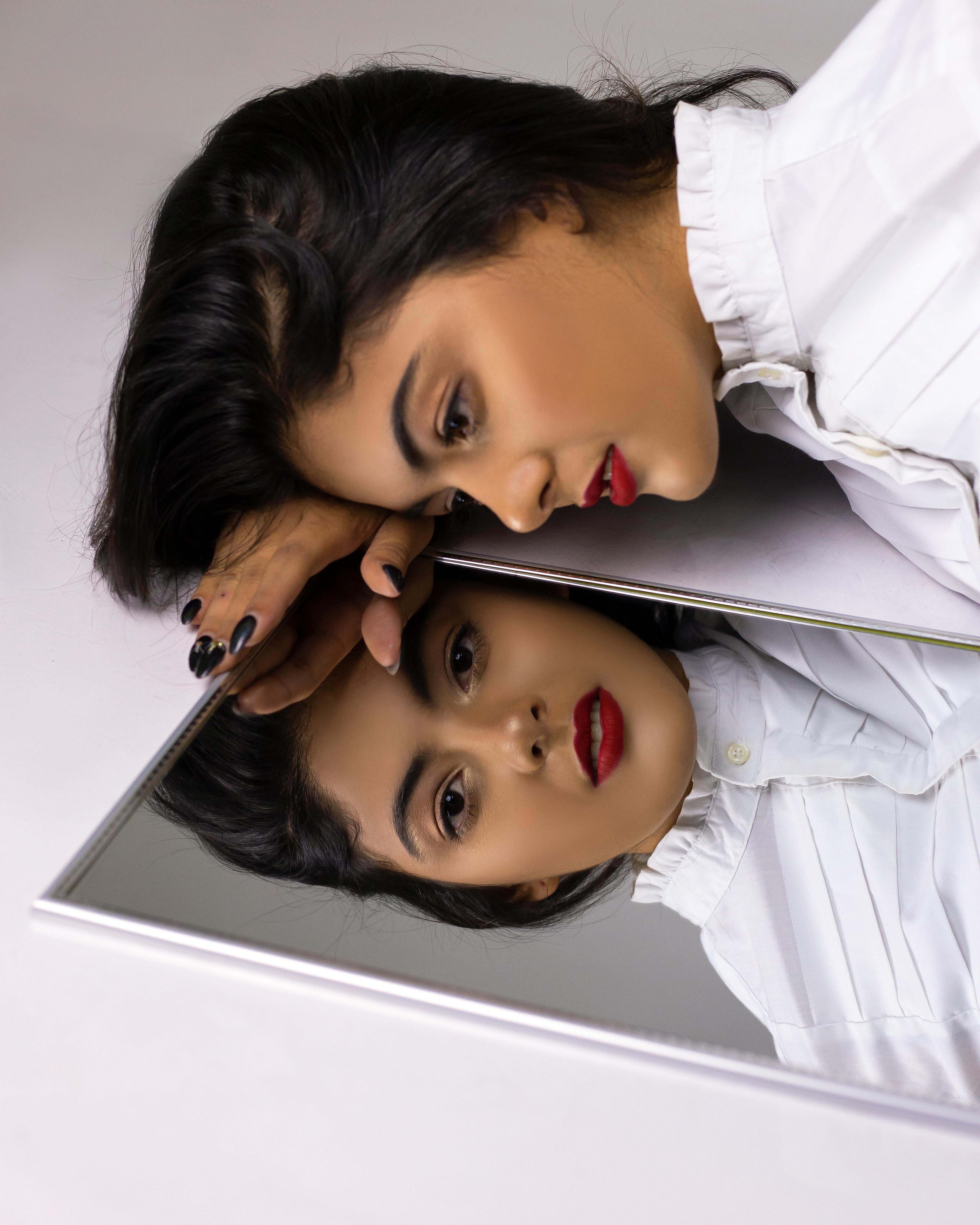 Calm woman looking at reflection of mirror · Free Stock Photo