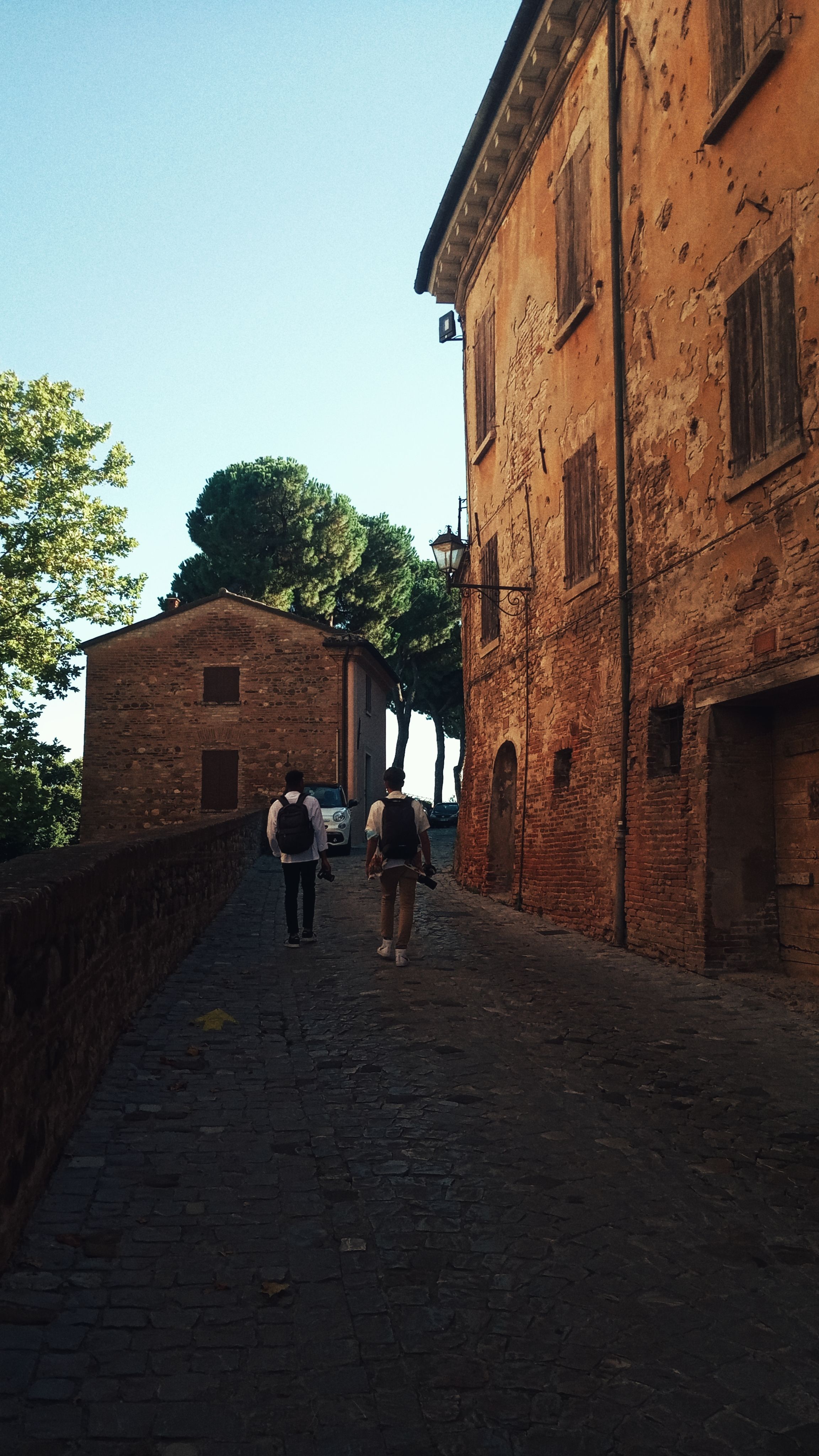 Faceless people walking near old buildings · Free Stock Photo