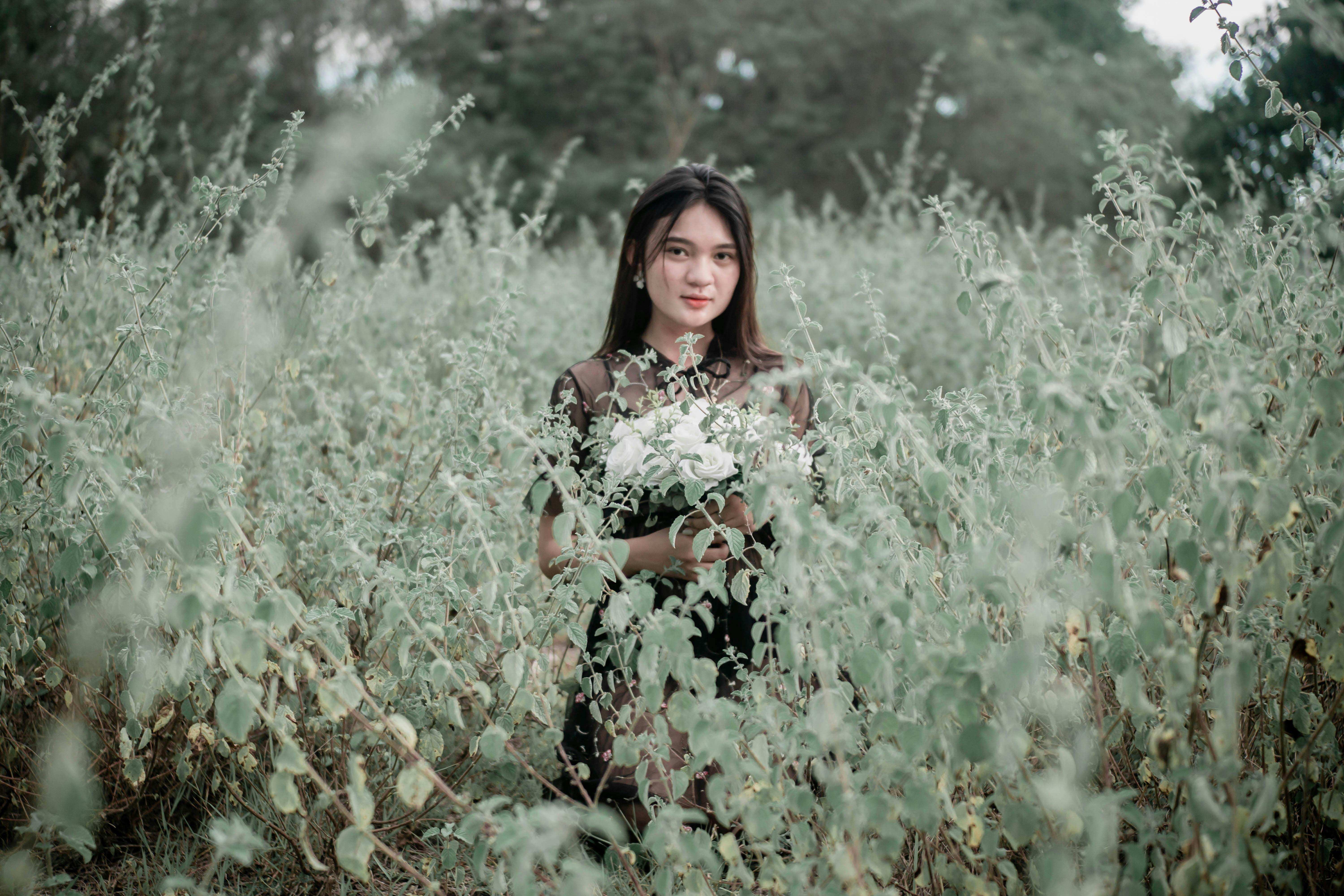Positive woman with bouquet of flowers in green meadow · Free Stock Photo