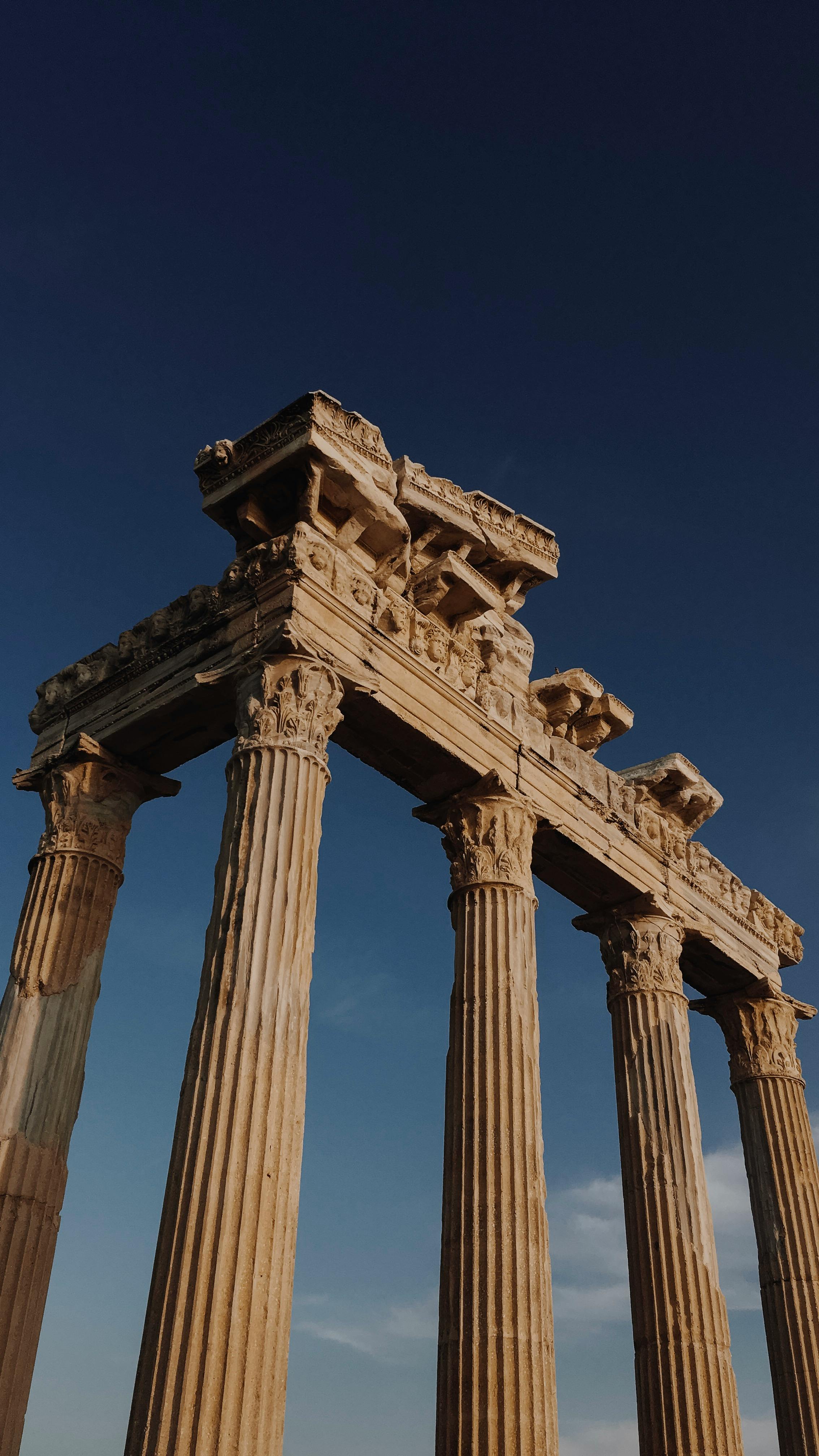 Old columns of ancient building against blue sky · Free Stock Photo