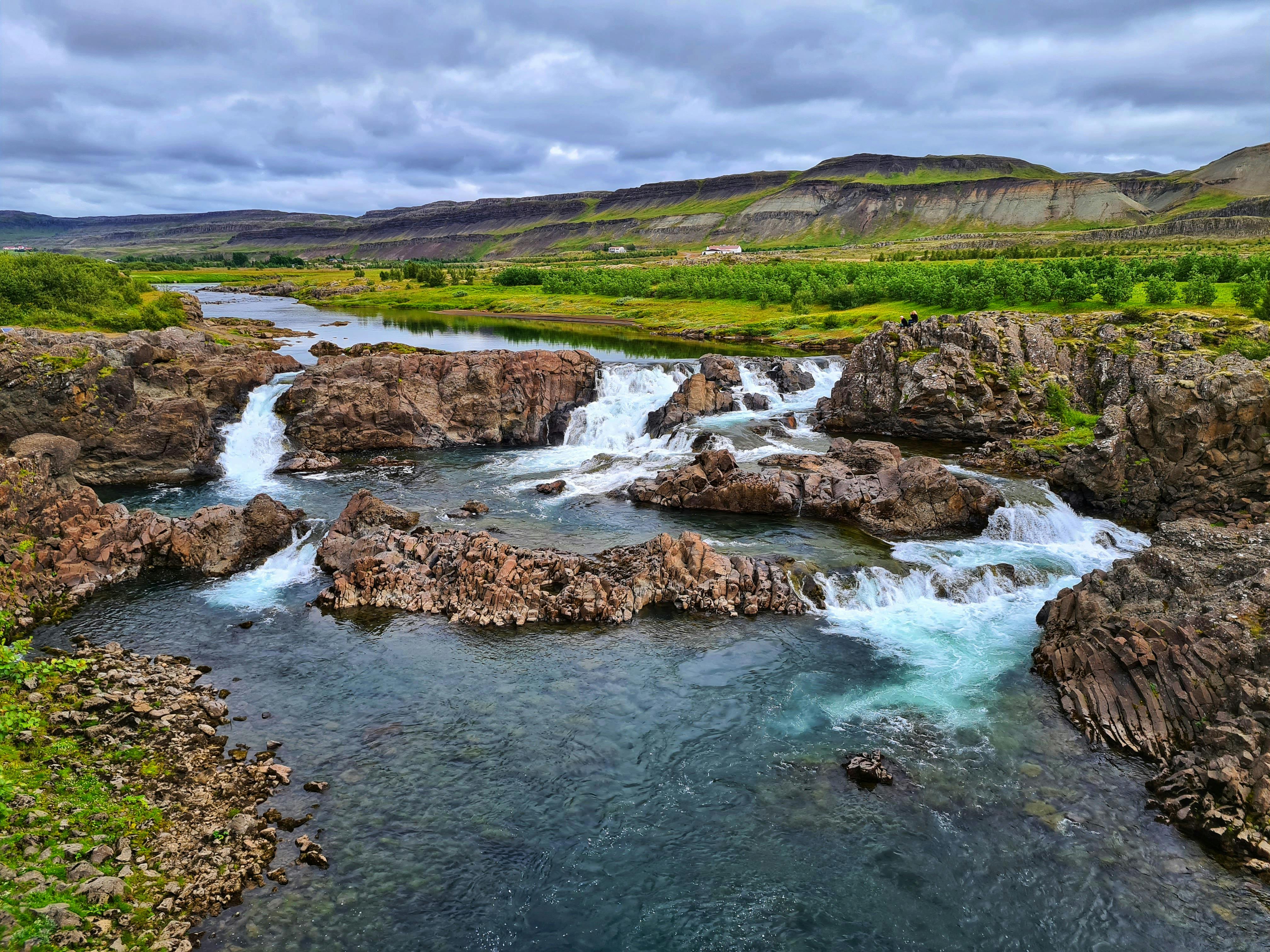 River streaming among mountainous valley on cloudy day · Free Stock Photo