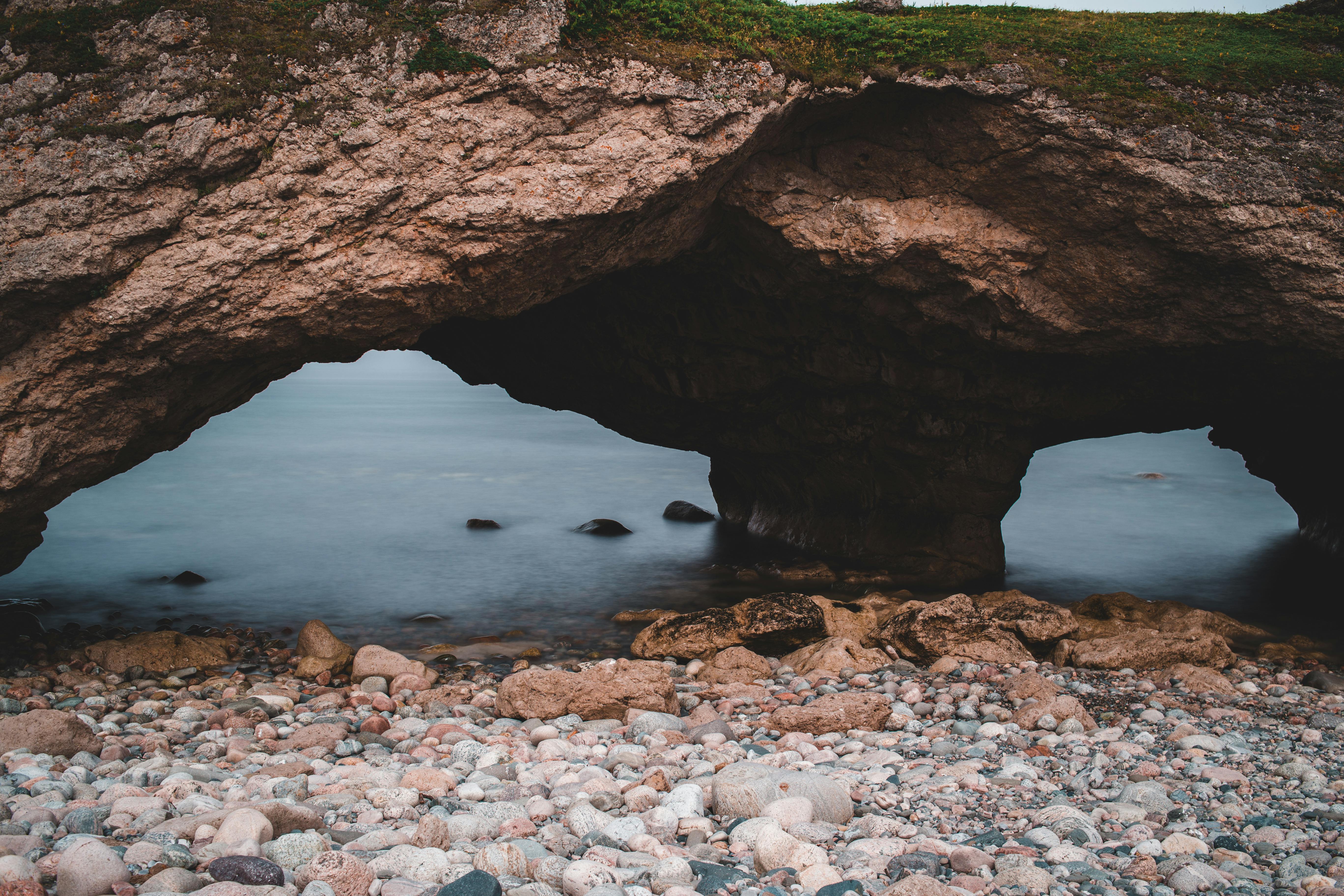 Arched cliff on beach of ocean · Free Stock Photo
