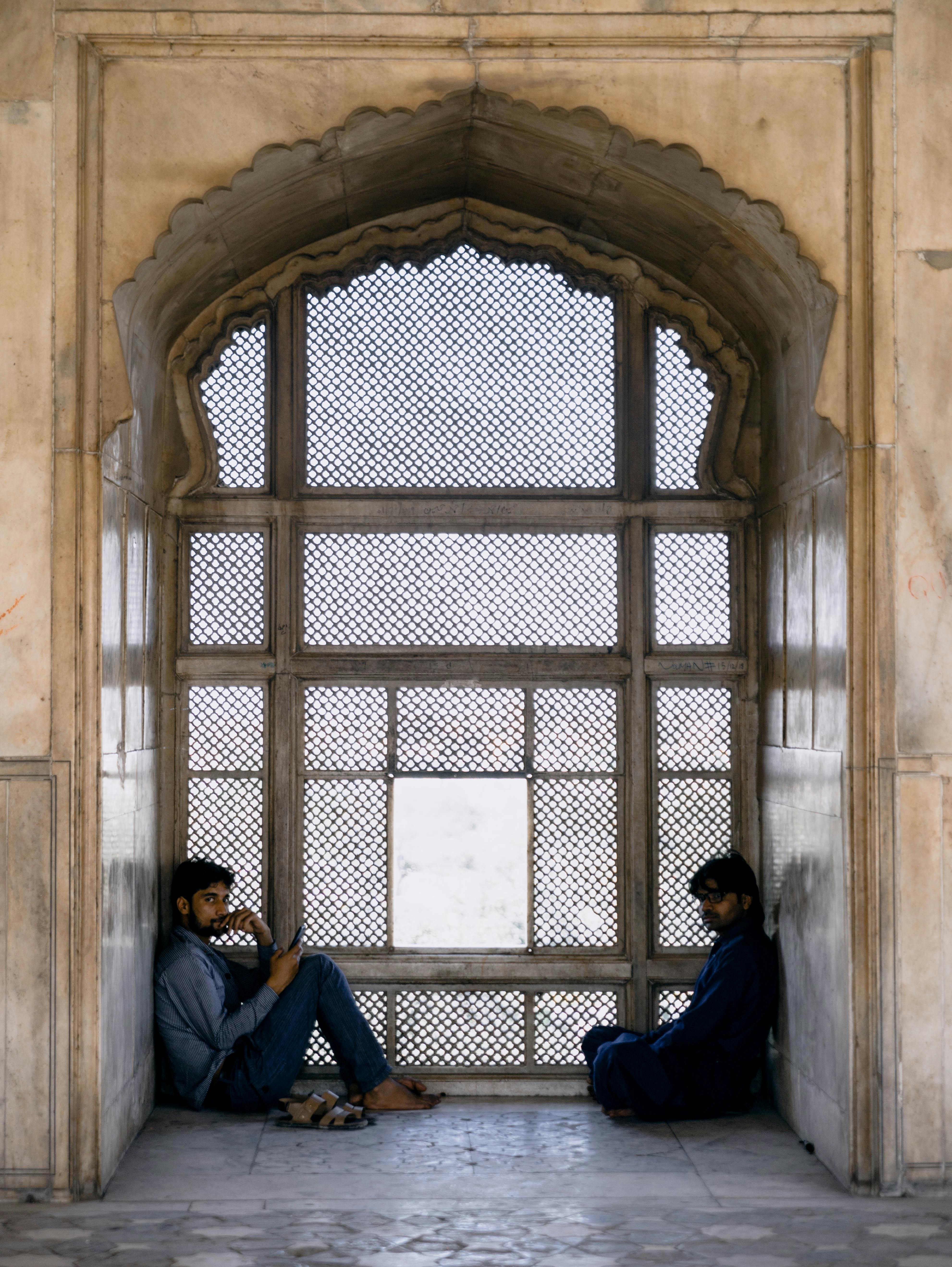 Young Men Sitting Near the Arched Window · Free Stock Photo