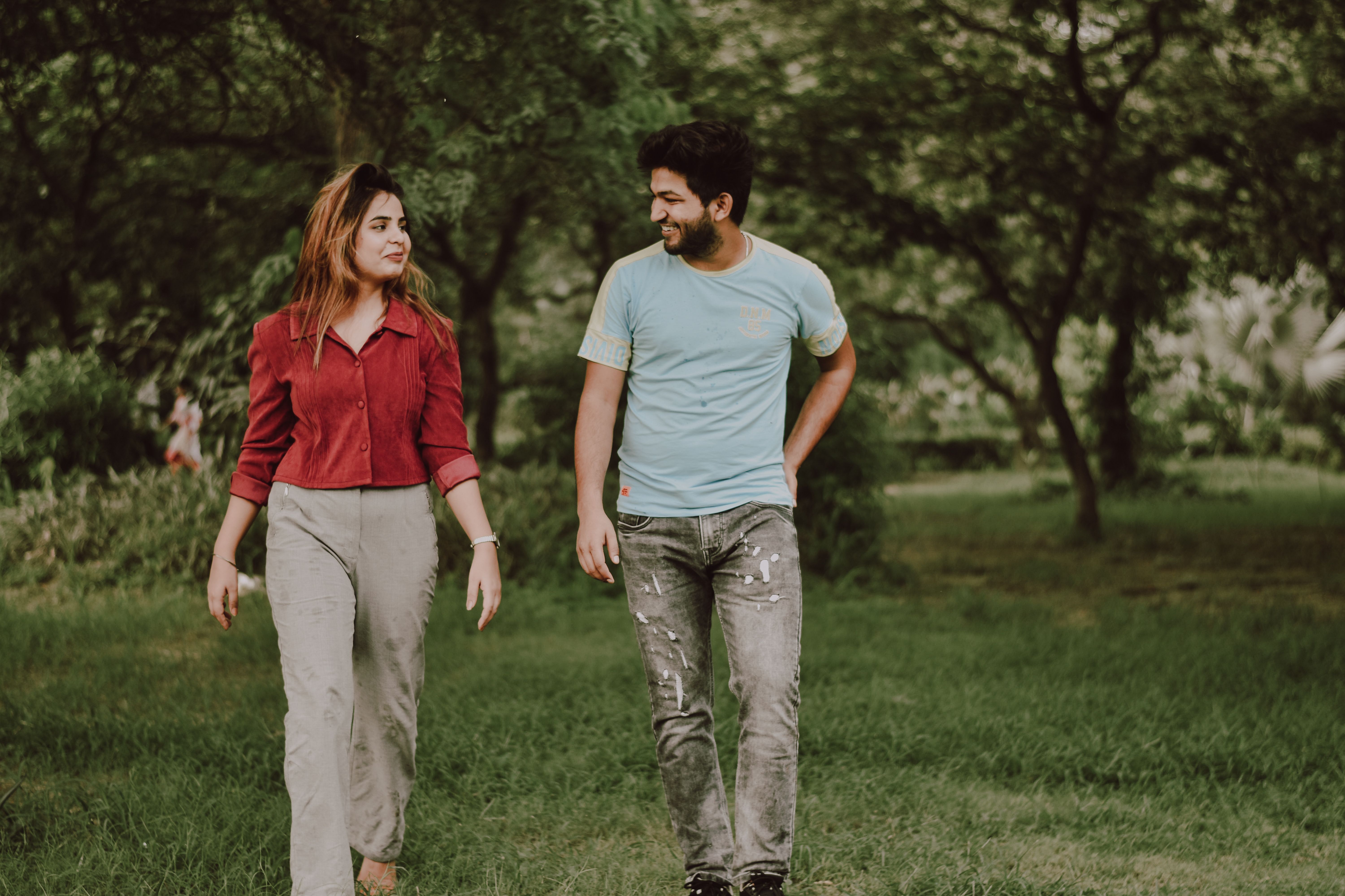 Happy young ethnic couple walking together in green park · Free Stock Photo