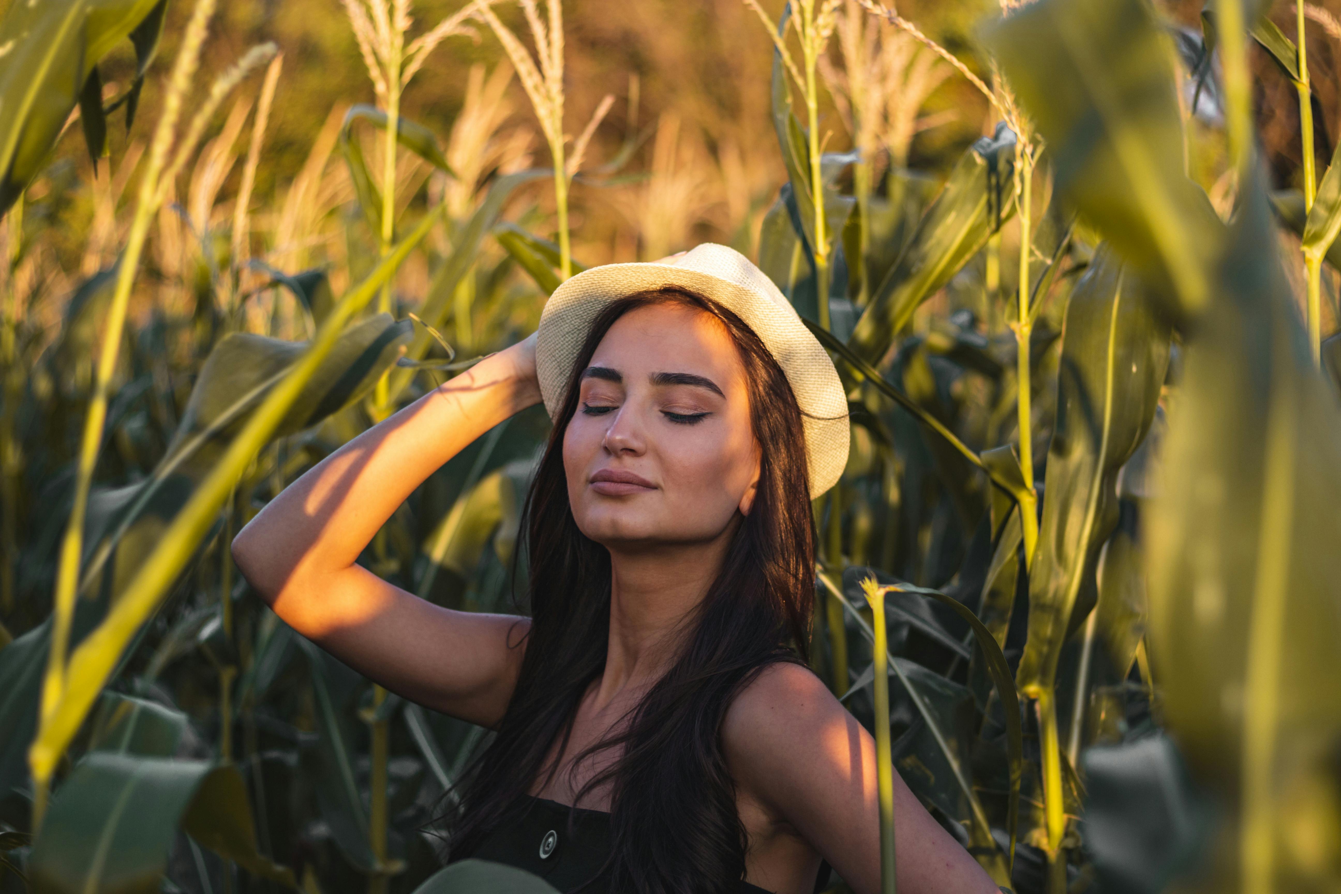 Woman Wearing a Hat Posing on Corn Field · Free Stock Photo
